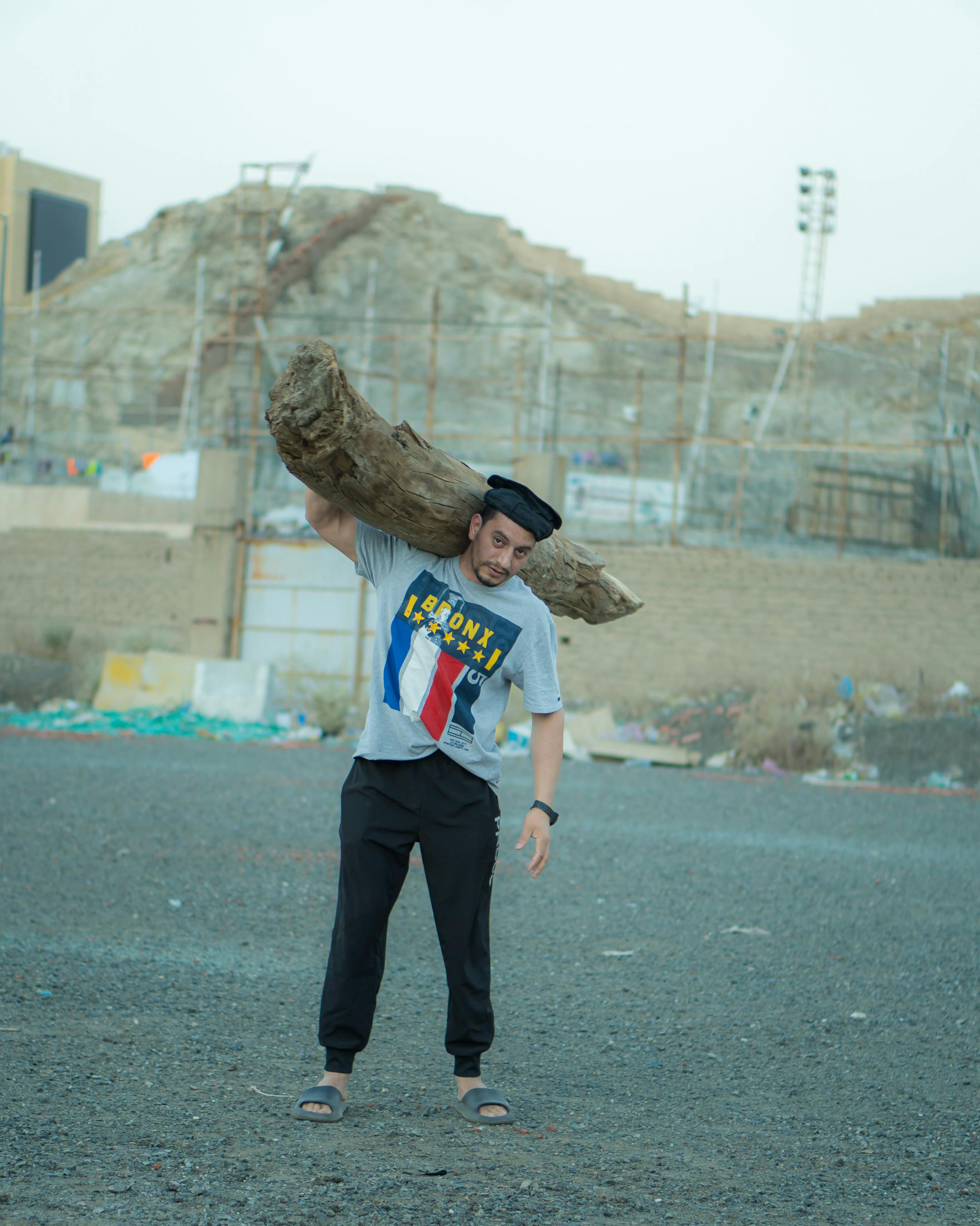 Man in T-shirt Carrying Tree Log · Free Stock Photo