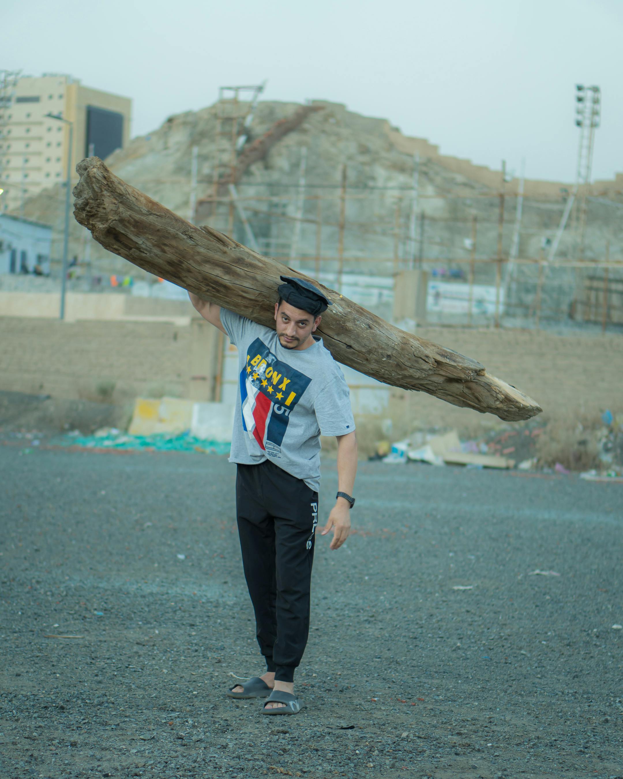 Man Carrying Wooden Log on his Shoulder at Construction Site · Free ...