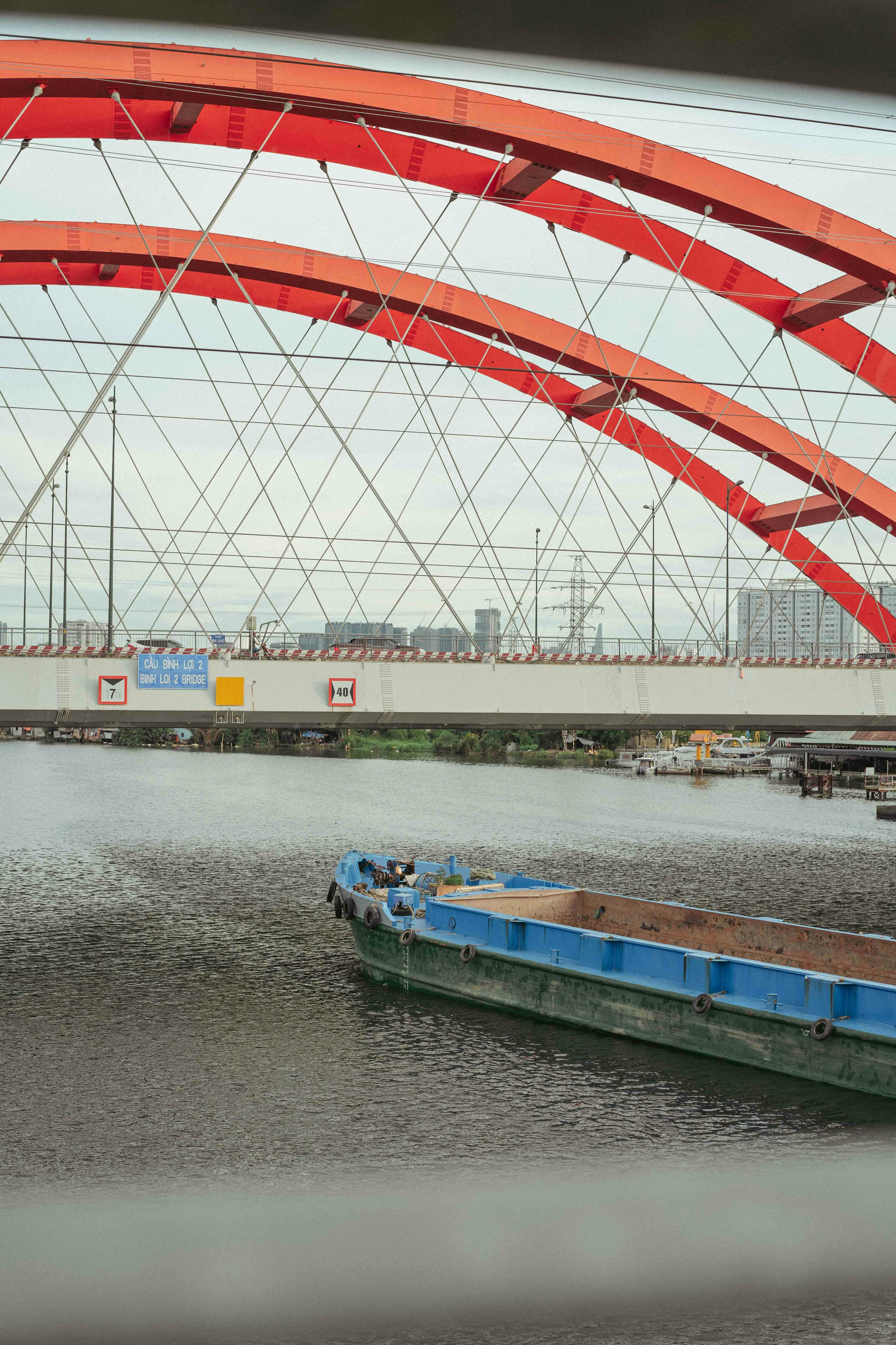 Transportation Ship Sailing Under Red Arch Bridge · Free Stock Photo