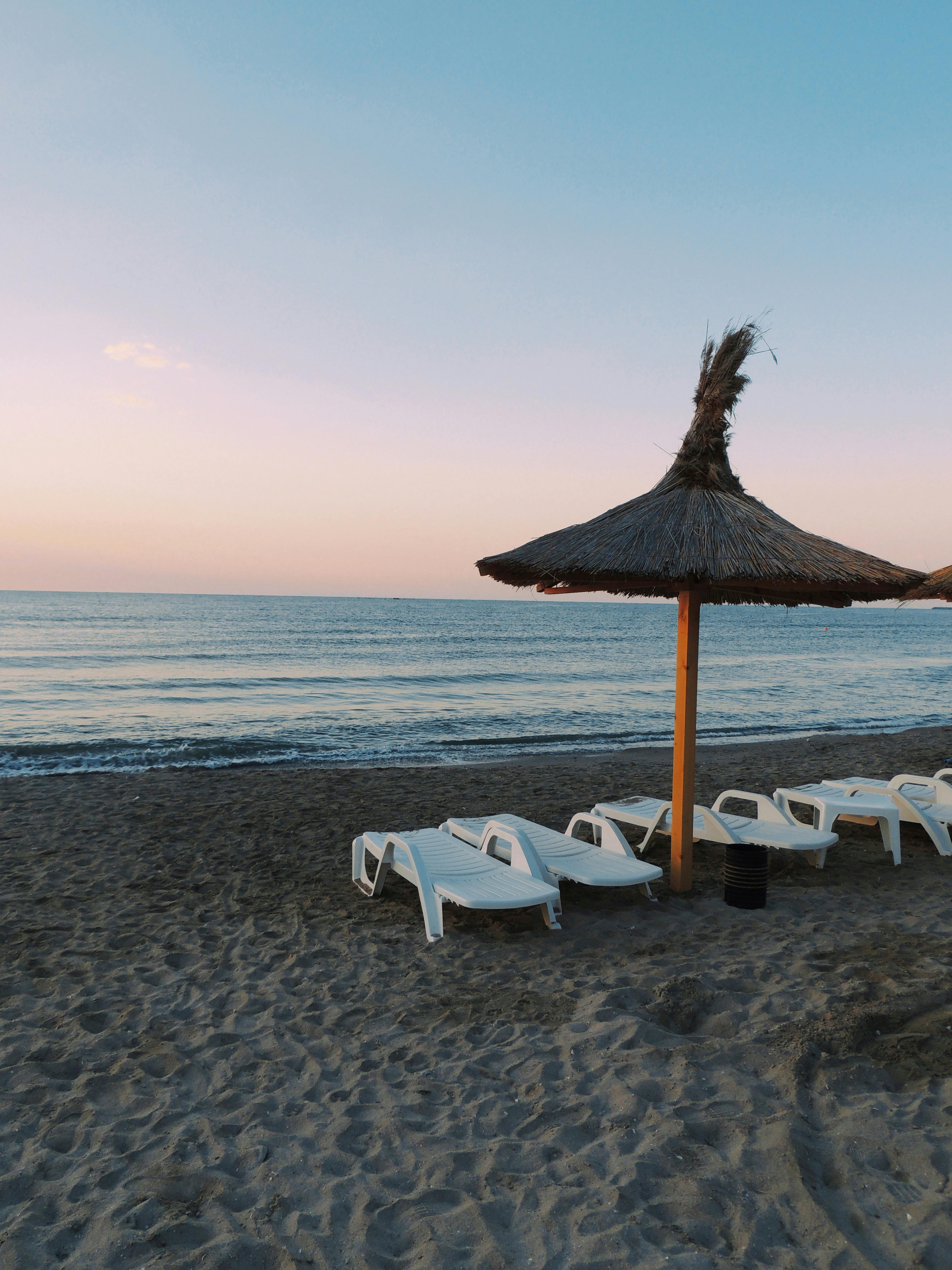 Photo of Sunloungers on Beach Near Sea · Free Stock Photo