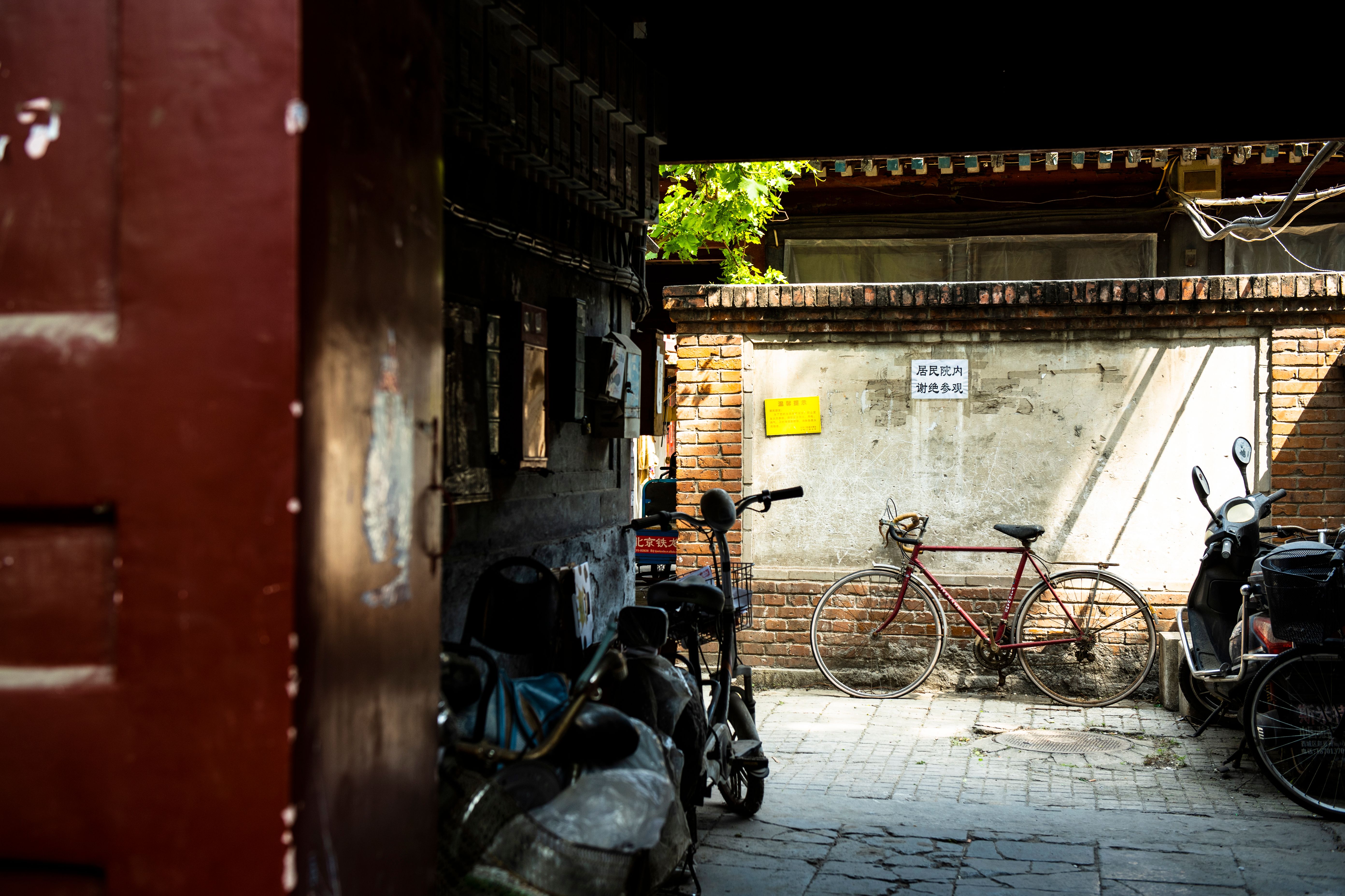 Black Motorcycle Standing by Brick Wall · Free Stock Photo