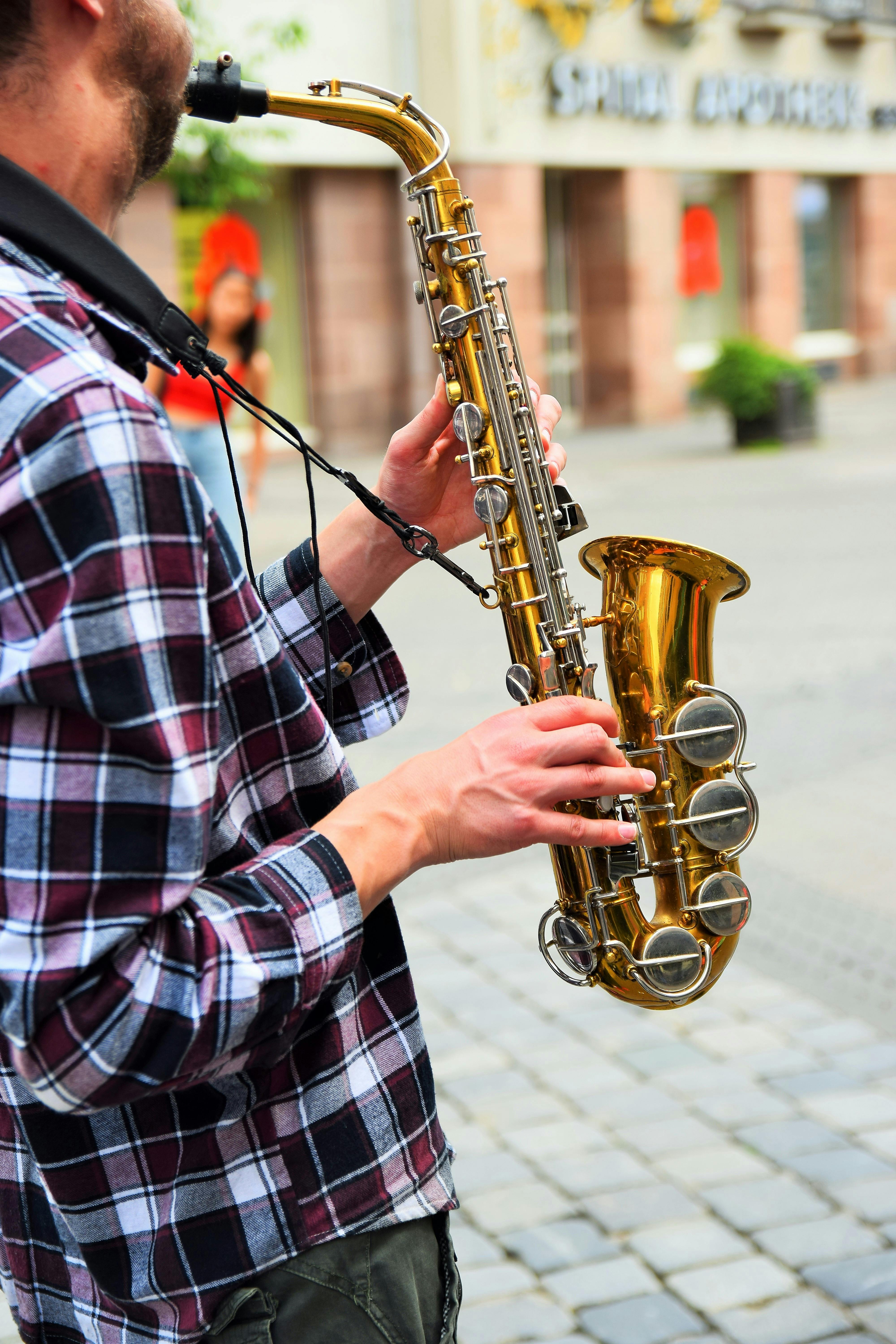 Man Sitting on Stool While Playing Saxophone Beside Fence · Free Stock ...
