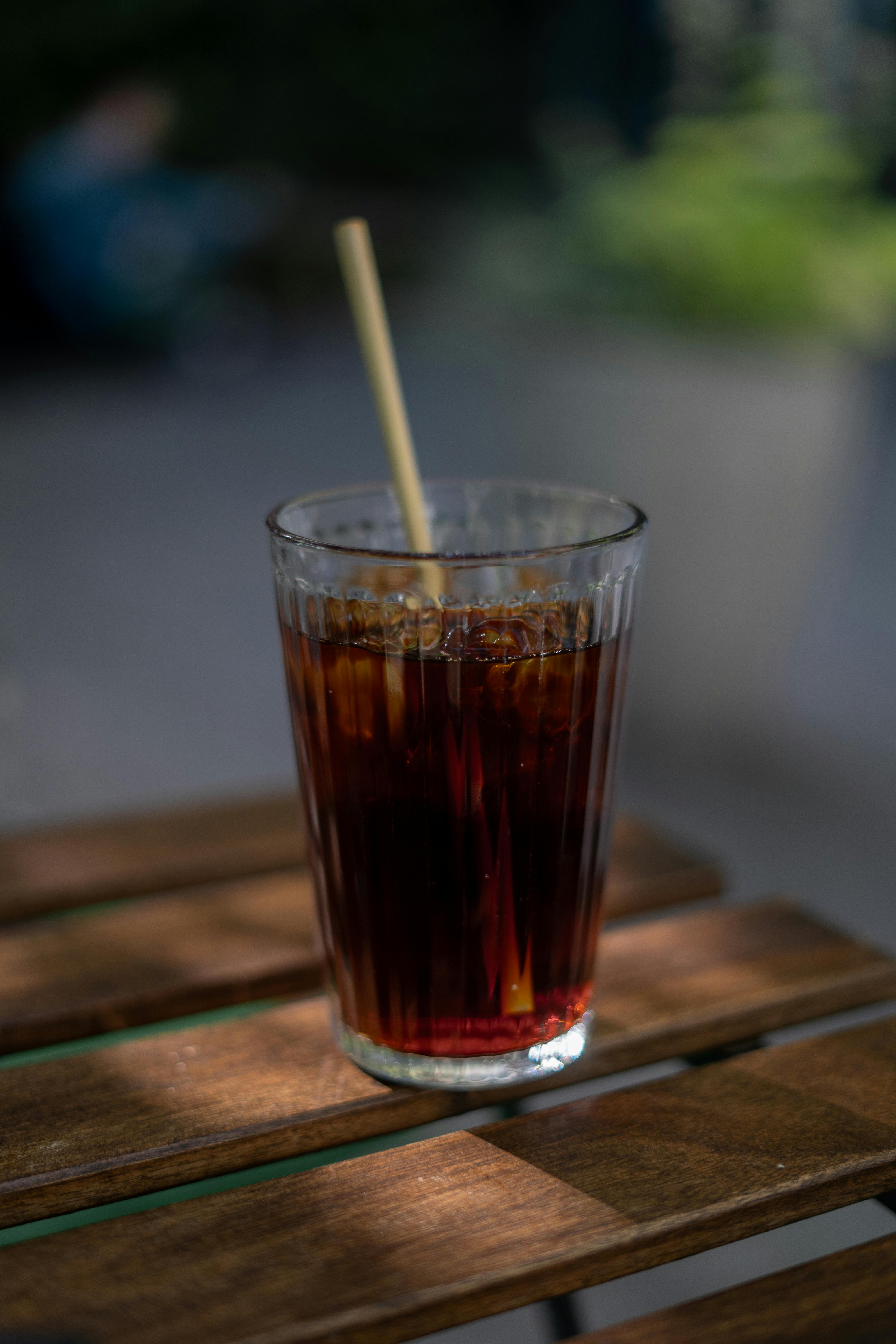 Close-up of a Glass with a Cold Drink and a Straw Standing on the Table ...