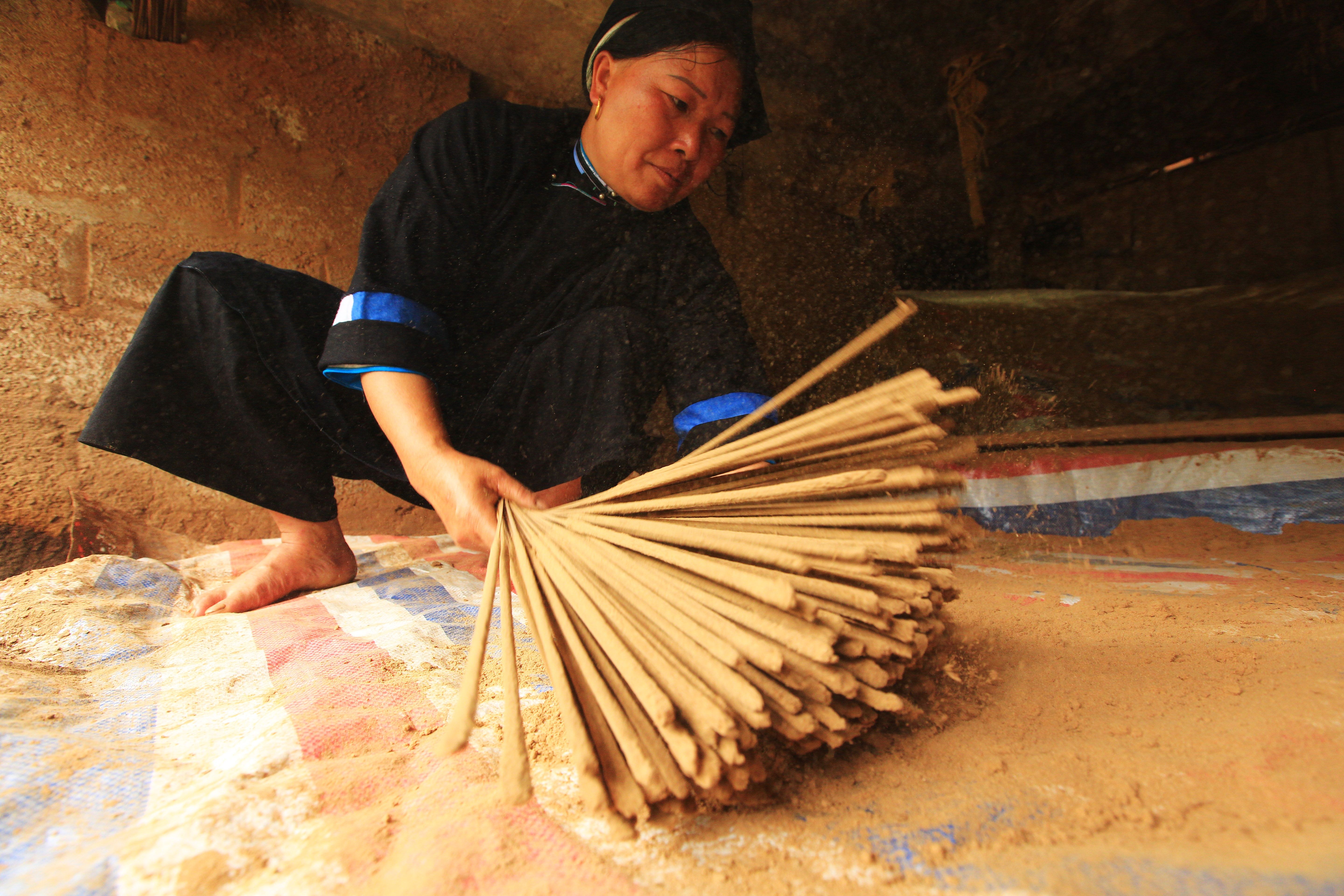 Woman Making Incense Sticks by Covering them with Powder · Free Stock Photo