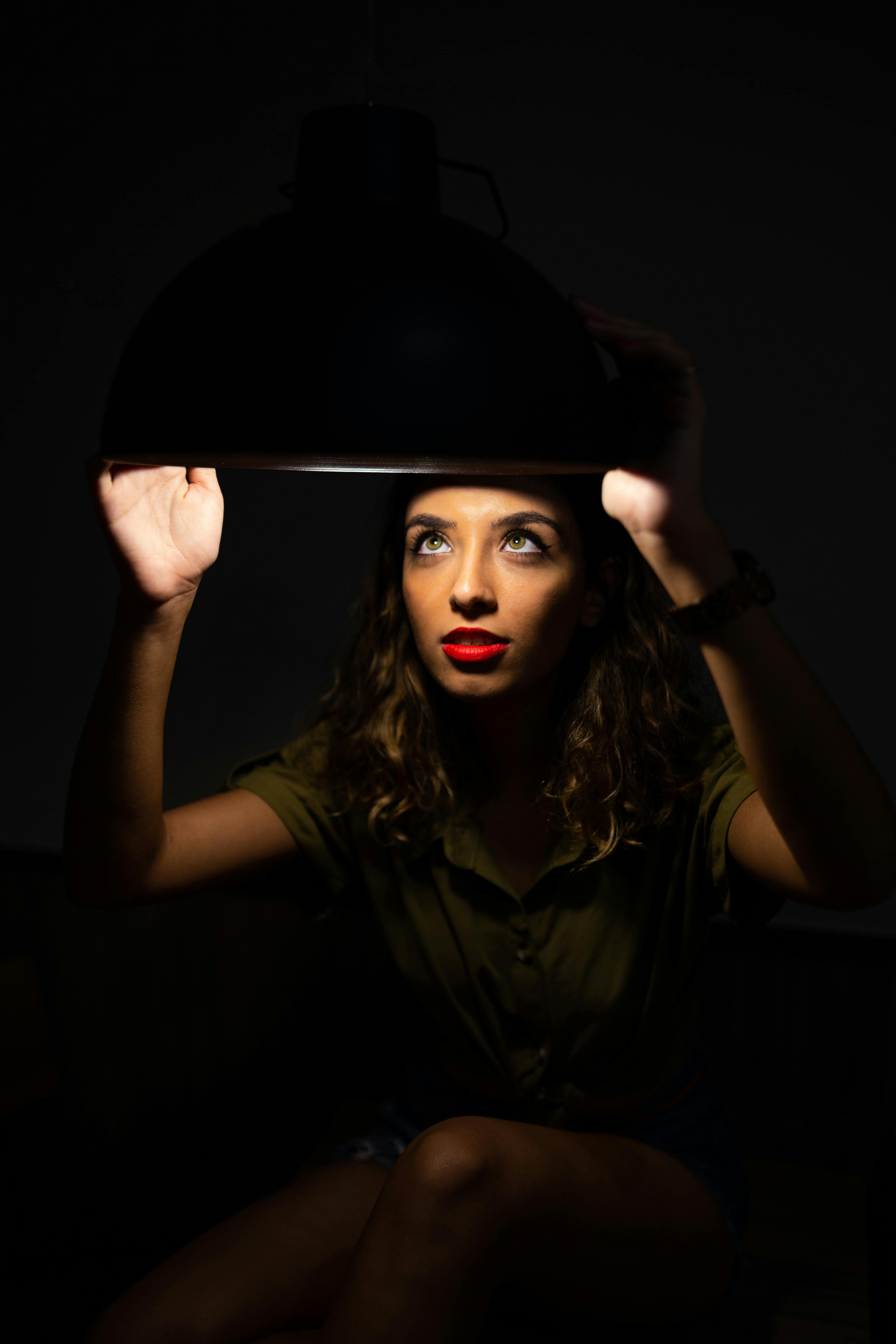 Photo of Woman Holding Lighted Ceiling Lamp · Free Stock Photo