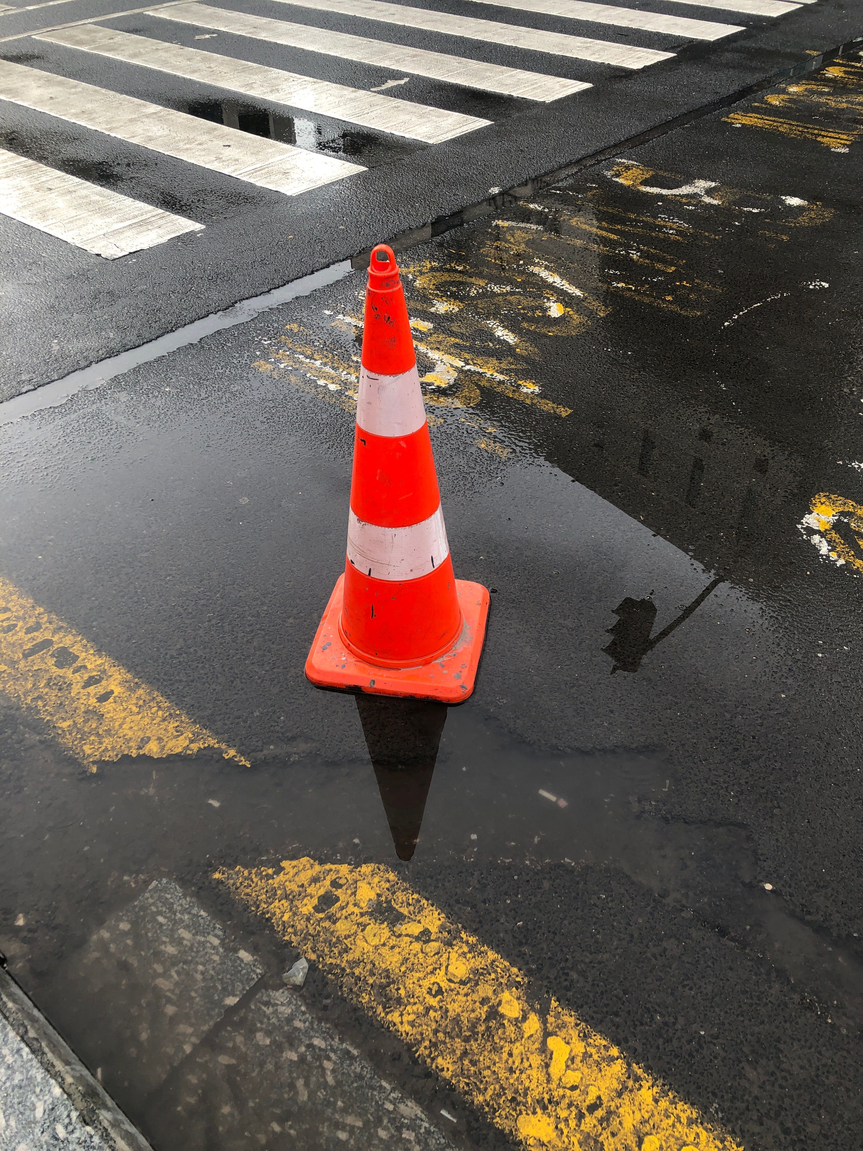 A Traffic Cone Standing on a Wet Street · Free Stock Photo