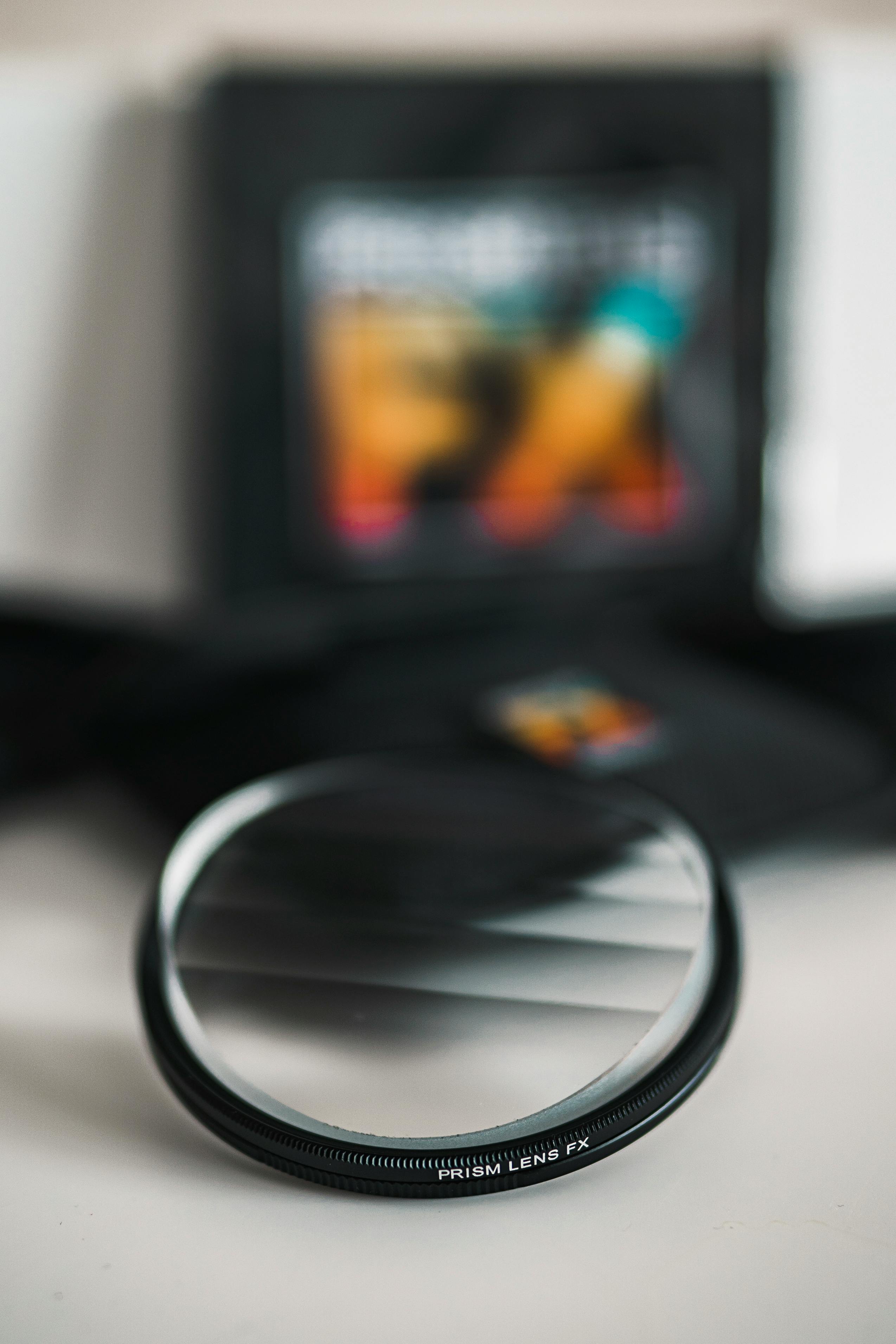 A lens filter with a black case next to it · Free Stock Photo