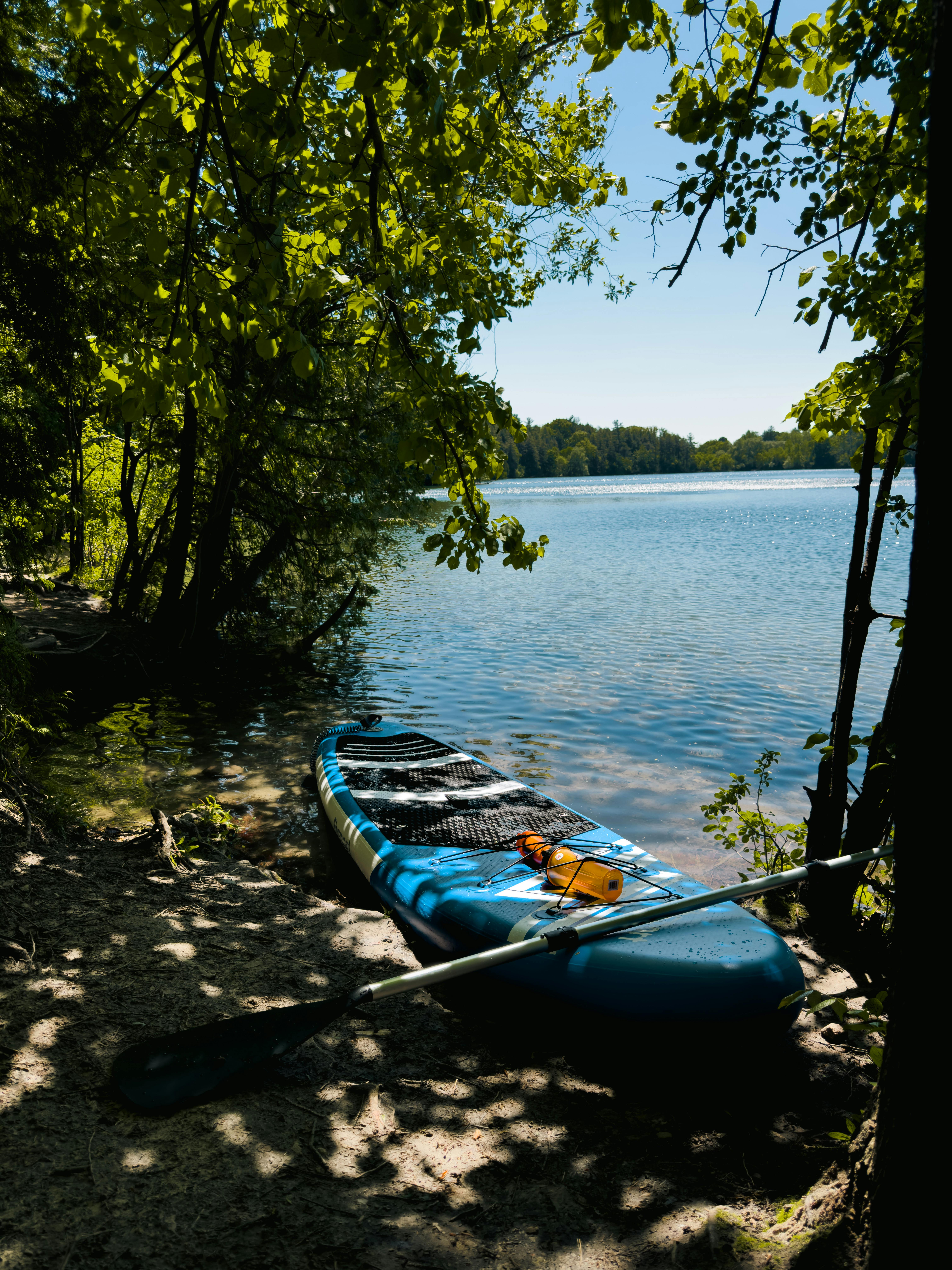 Kayak Left on Lake Shore under Tree Shade · Free Stock Photo