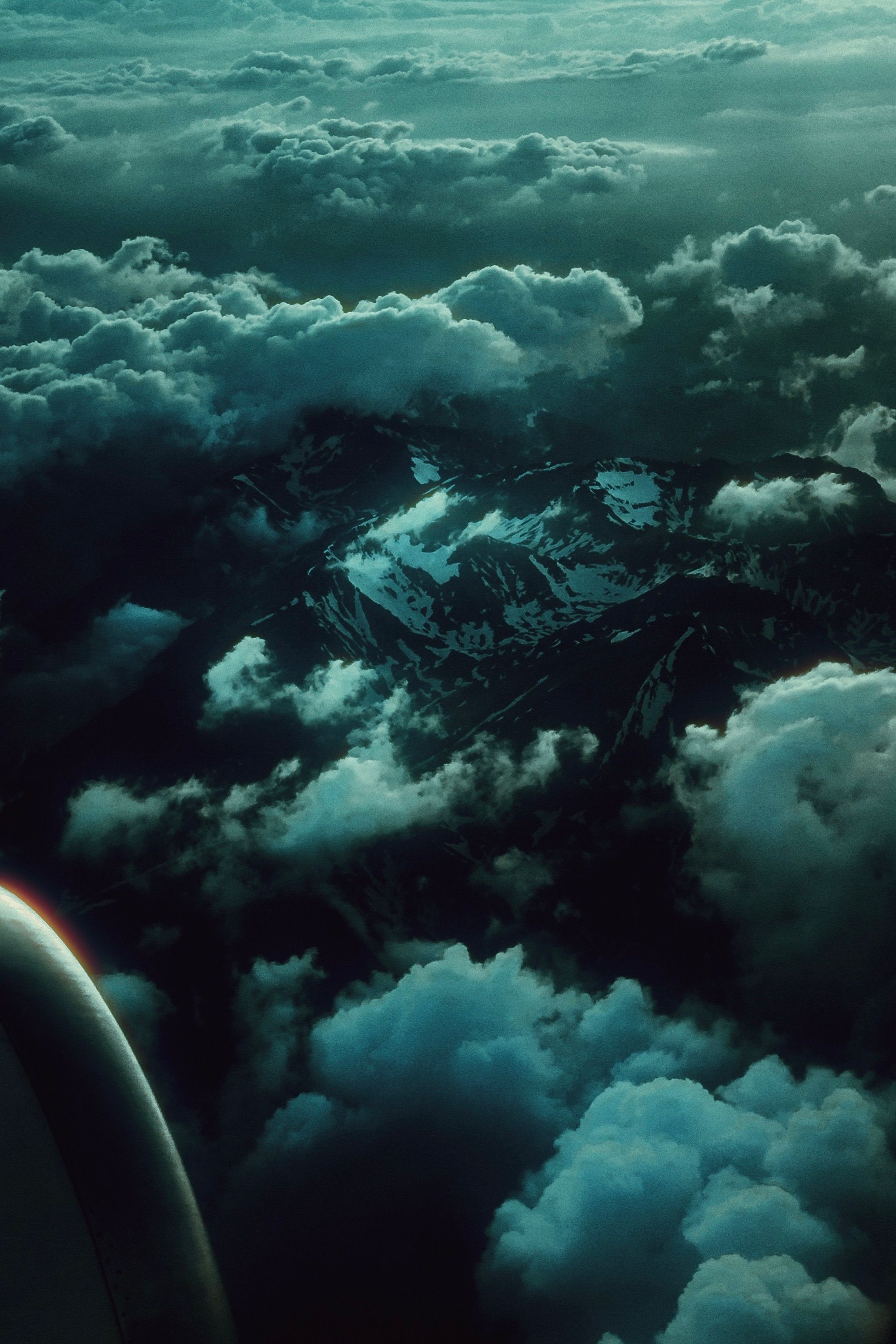 Aerial View of Mountain Range below Clouds · Free Stock Photo
