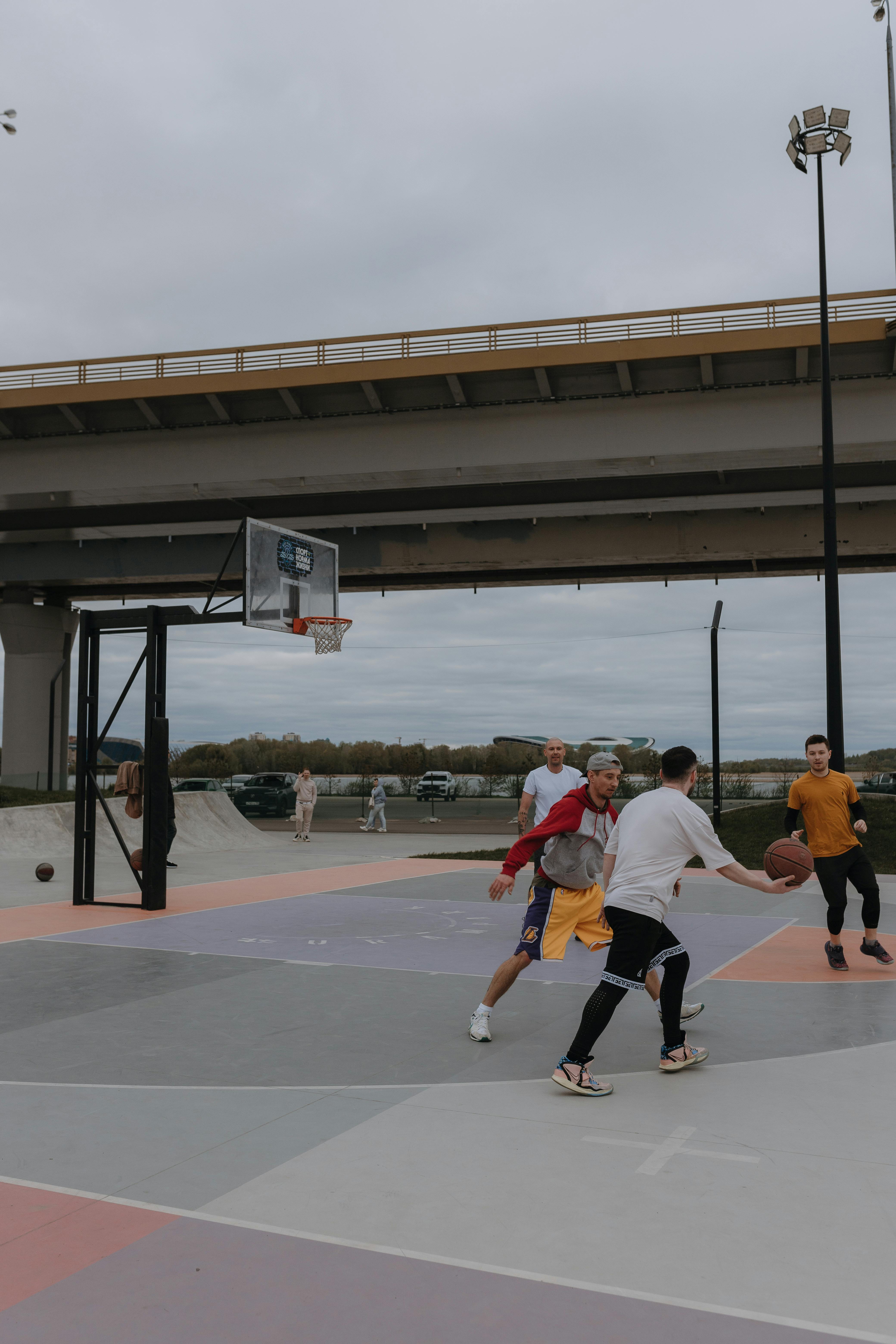 Young Men Playing Basketball under a Bridge · Free Stock Photo