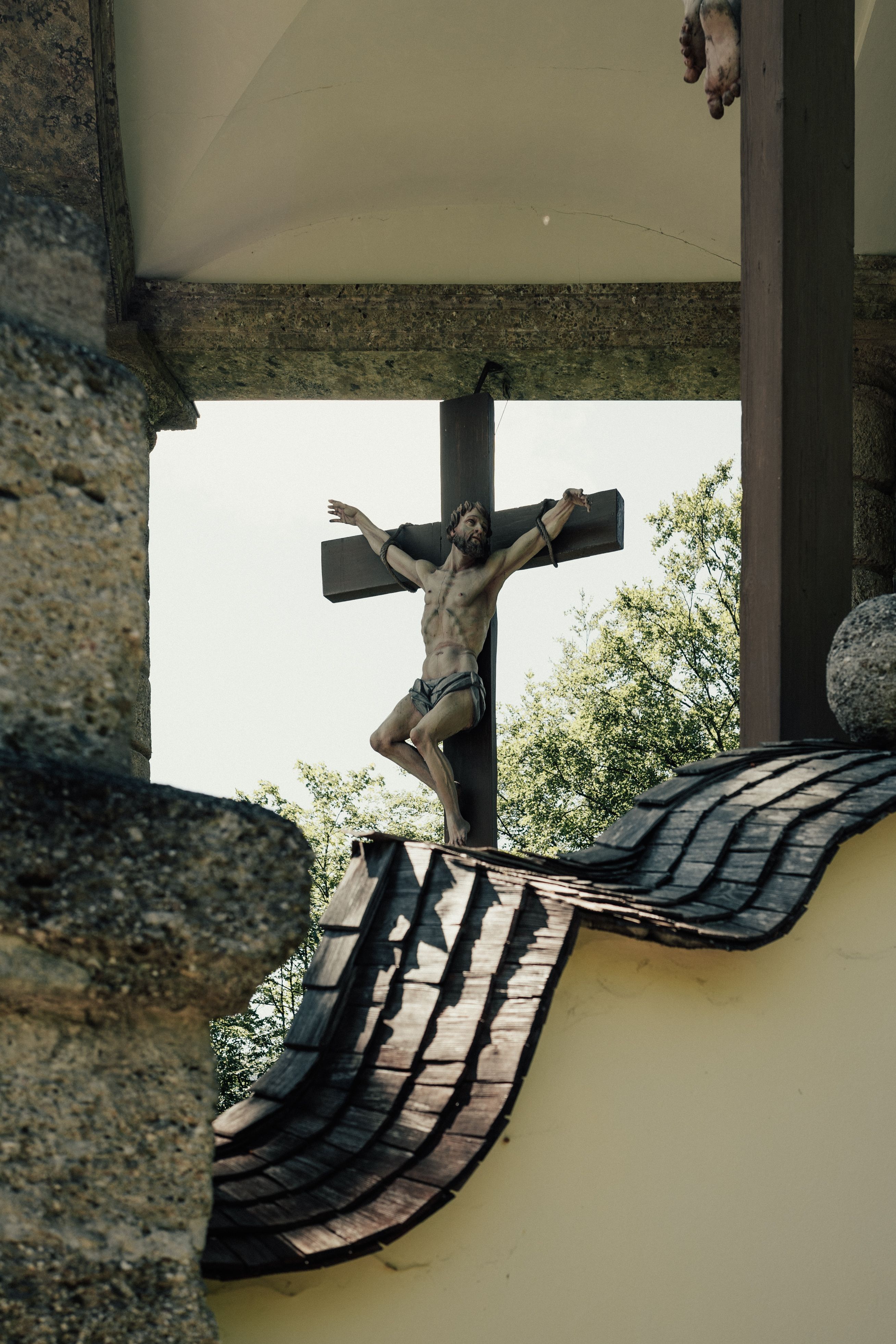 A cross on top of a building with a statue of jesus · Free Stock Photo