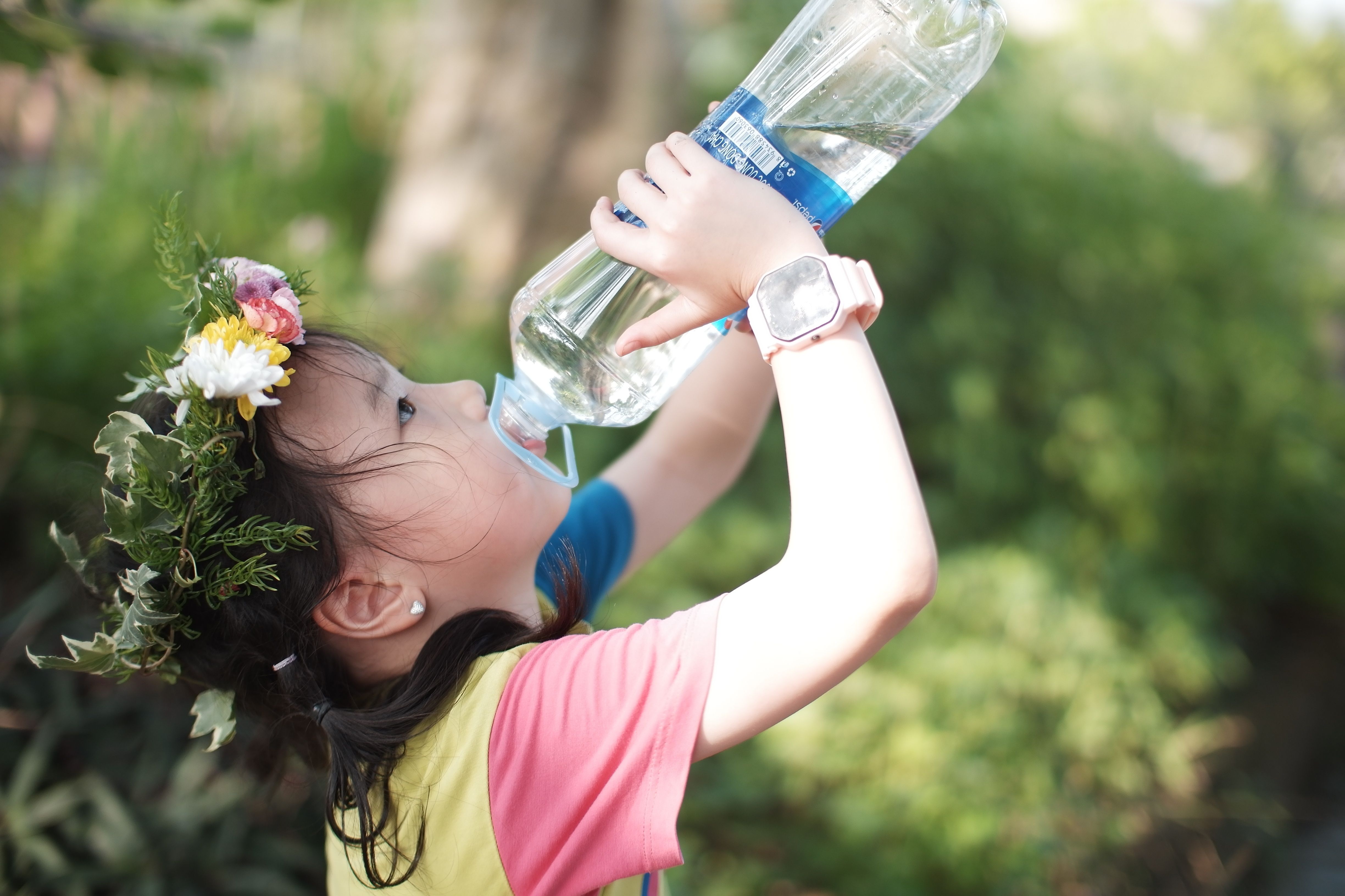 Little girl is drinking water from a bottle · Free Stock Photo