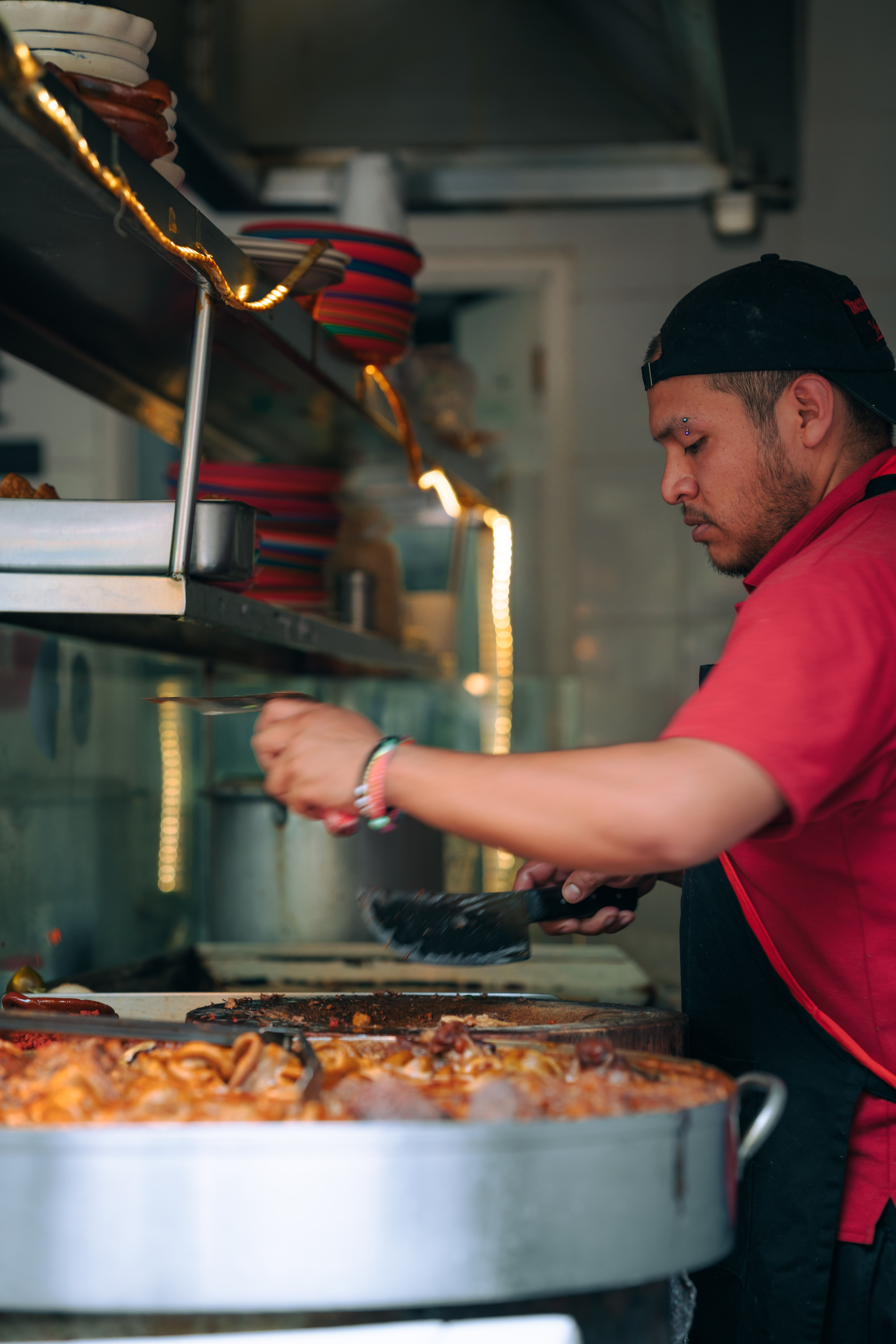 A man in red shirt cooking food in a kitchen · Free Stock Photo