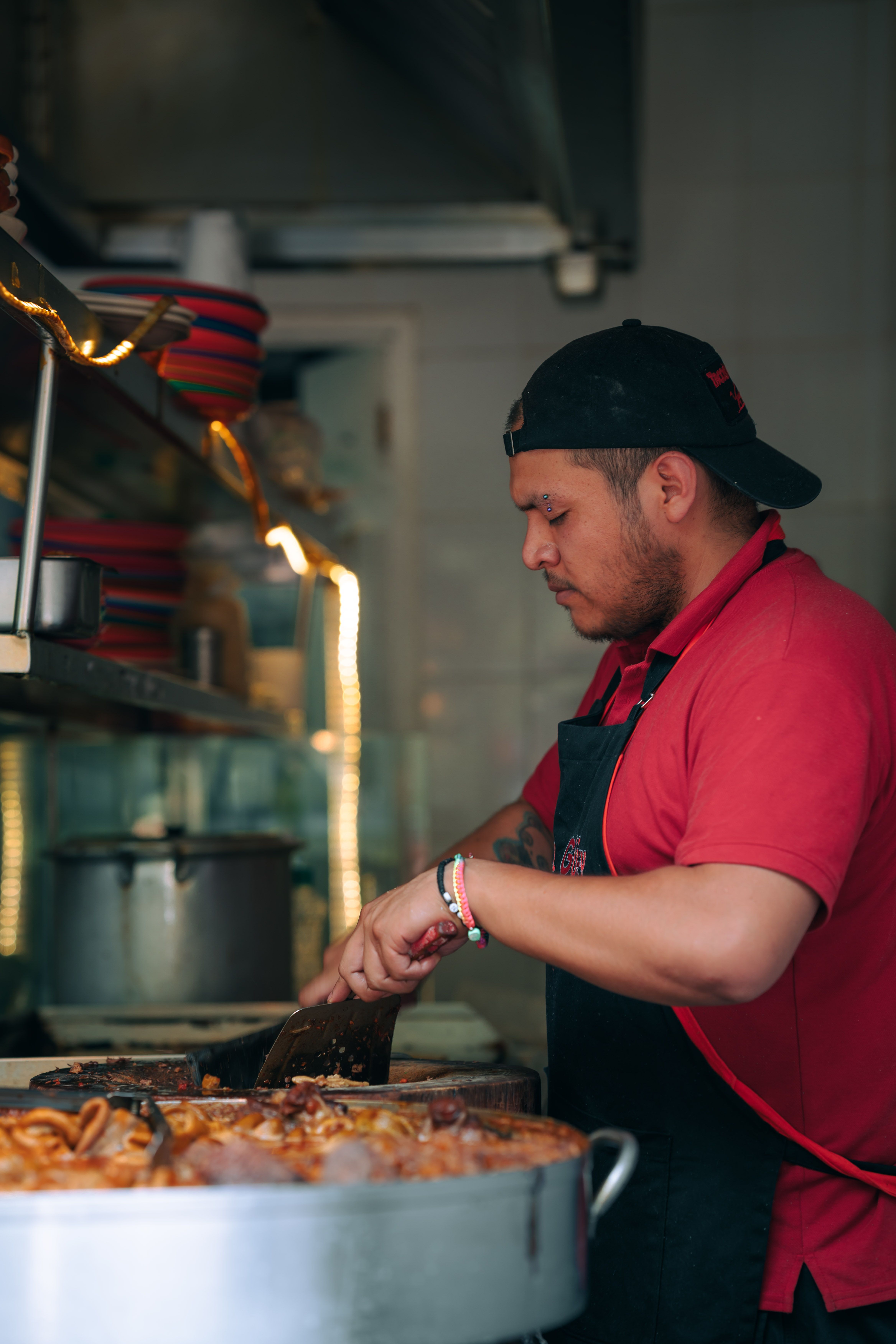 A man in a red shirt cooking food in a kitchen · Free Stock Photo
