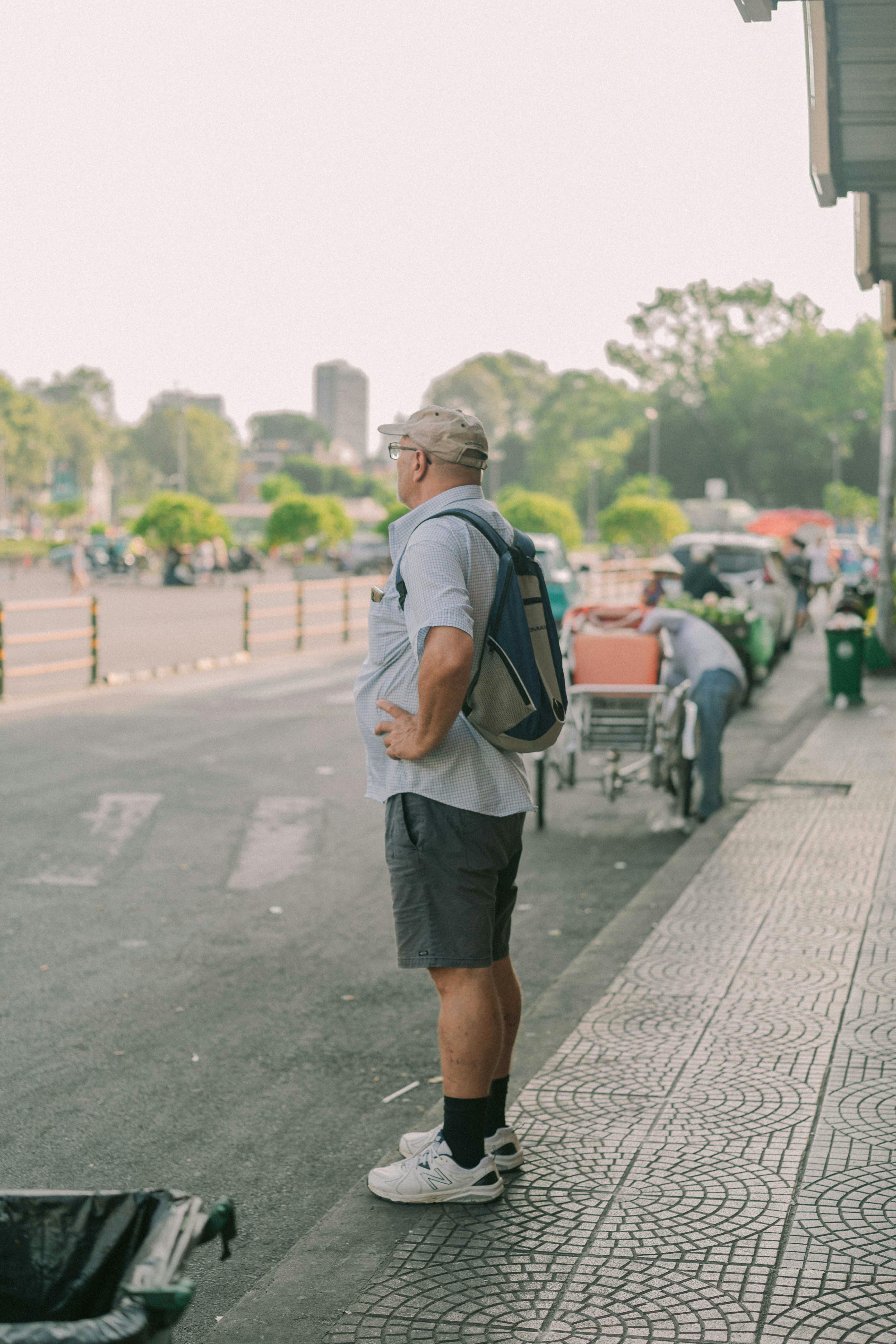Side View of a Man Standing on the Sidewalk · Free Stock Photo