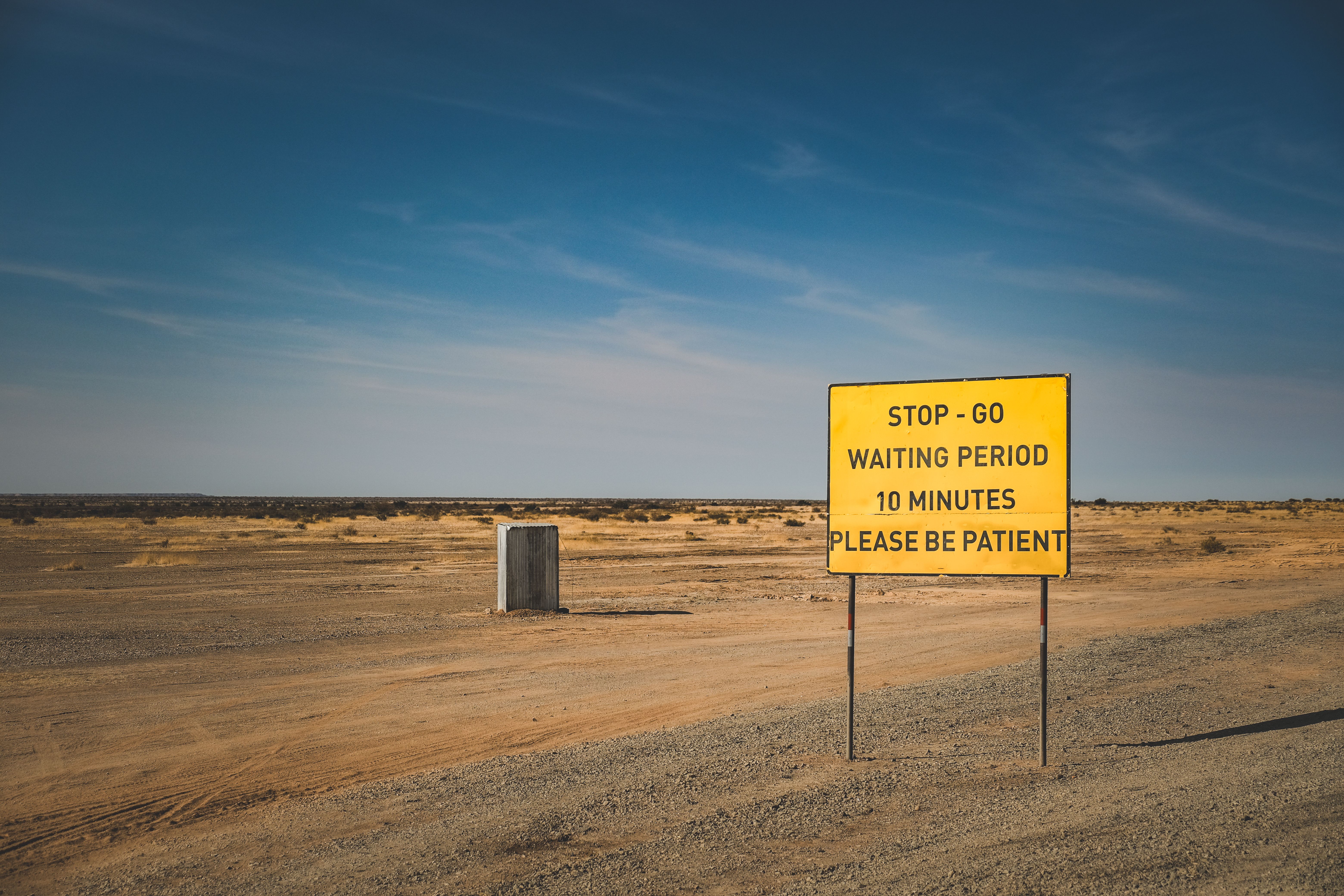 A sign in the desert with a yellow warning sign · Free Stock Photo