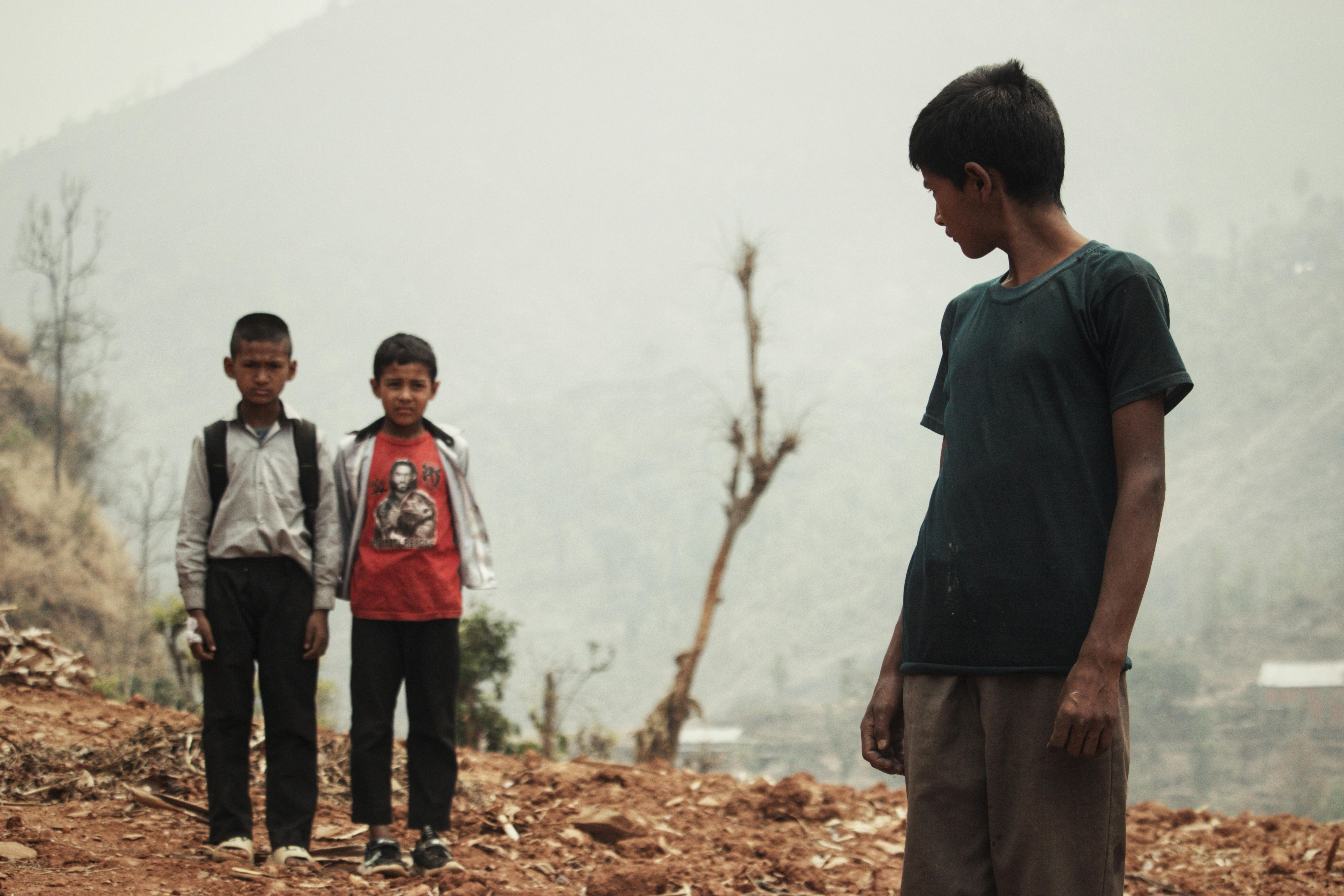 Three Boys Standing Outdoors Looking at Each Other · Free Stock Photo