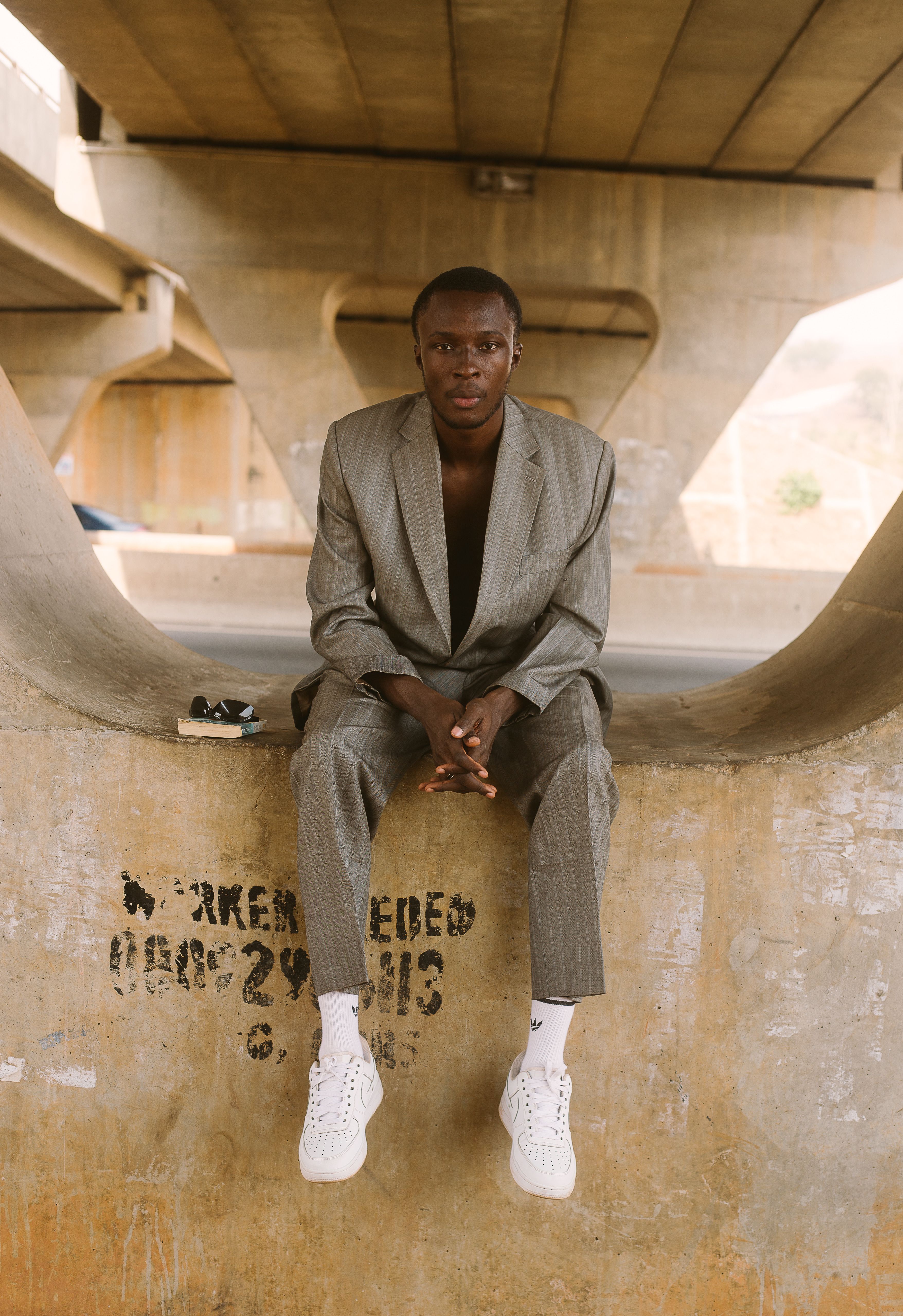 A man sitting on a concrete ledge in a suit · Free Stock Photo