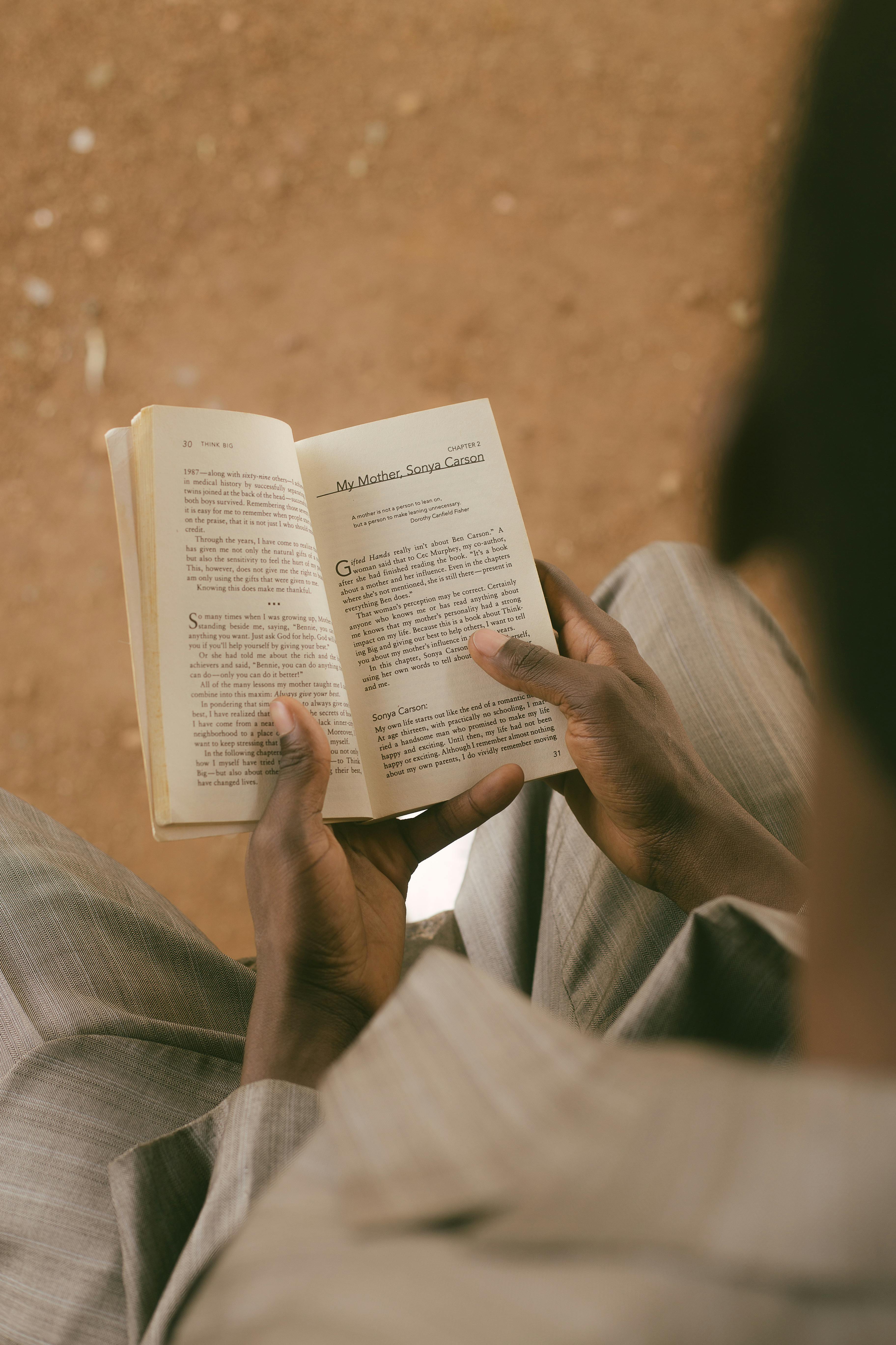 Hands of Man Holding and Reading Book · Free Stock Photo