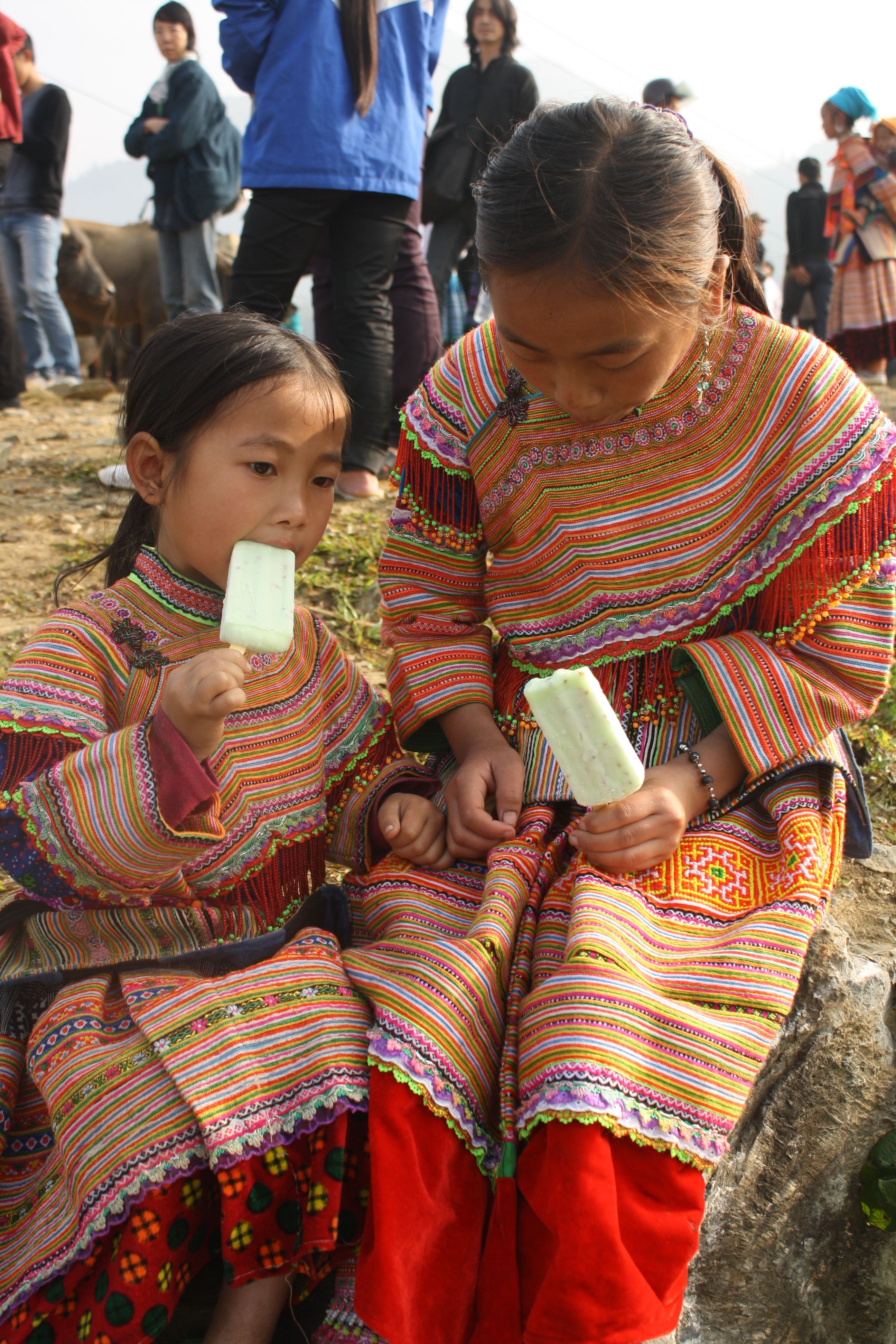Two young girls in traditional clothing eating ice cream · Free Stock Photo