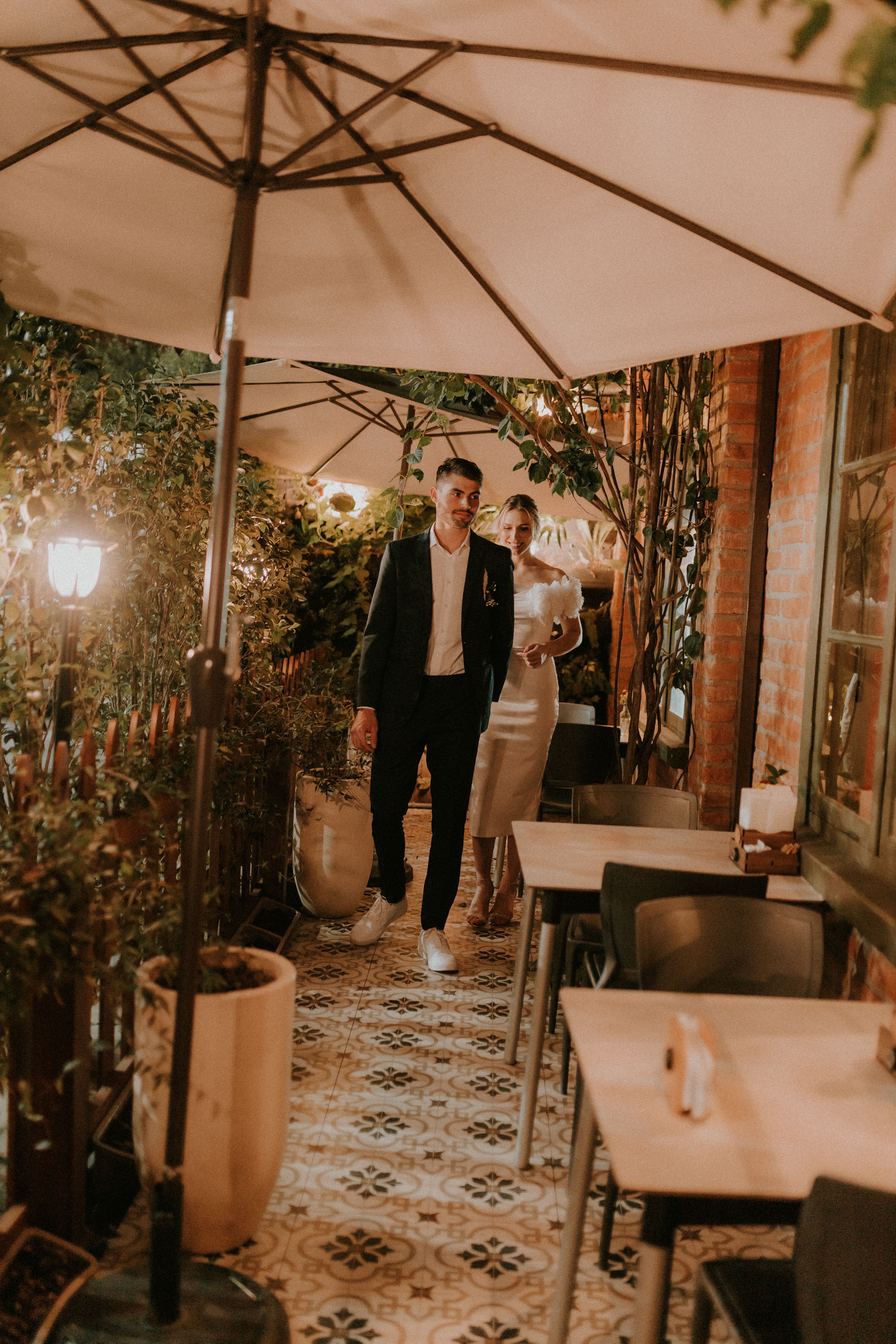 A couple walking through an outdoor restaurant · Free Stock Photo