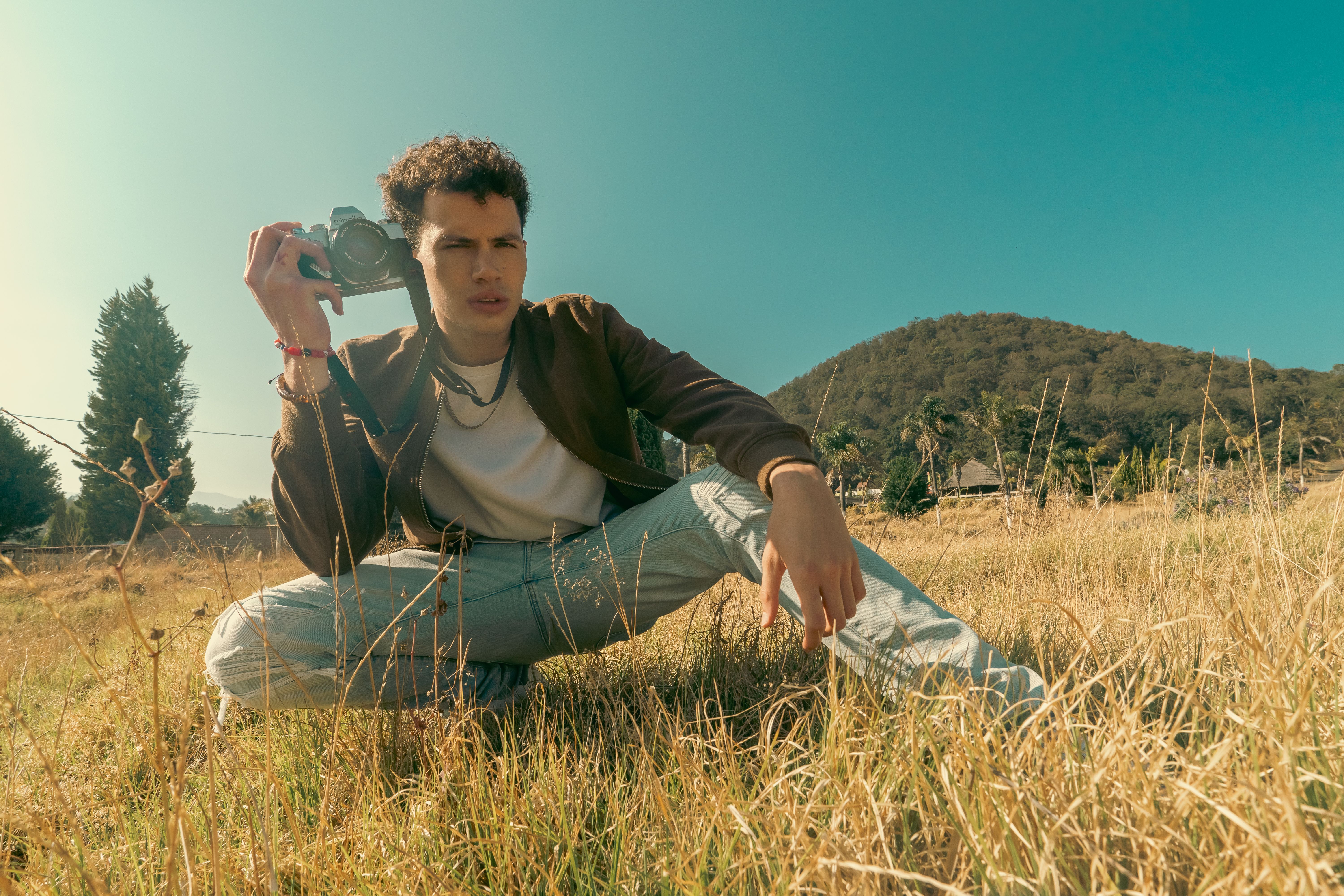 Photographer Crouching in a Field · Free Stock Photo