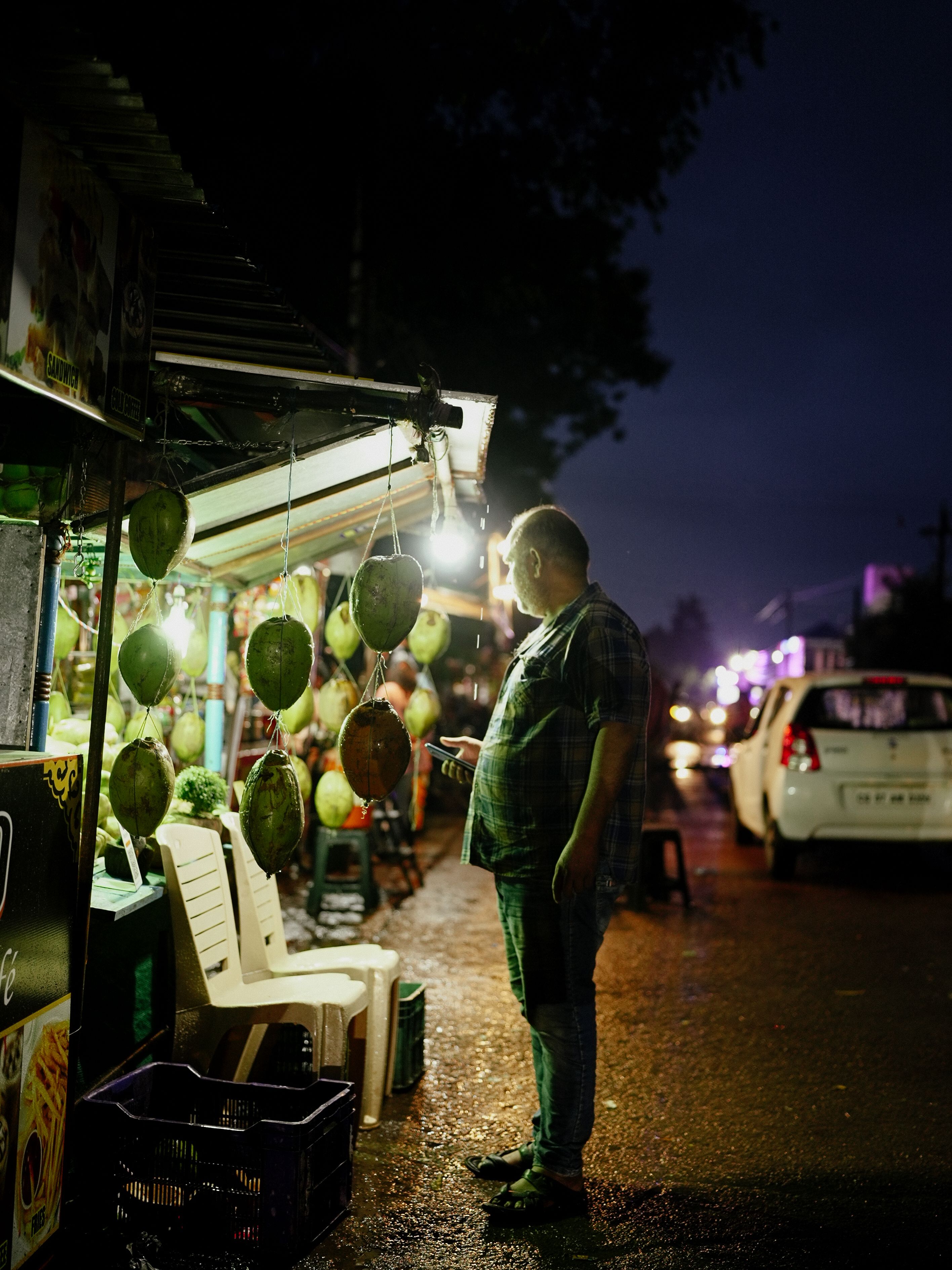 Man Standing in front of a Market Stall at Dusk · Free Stock Photo