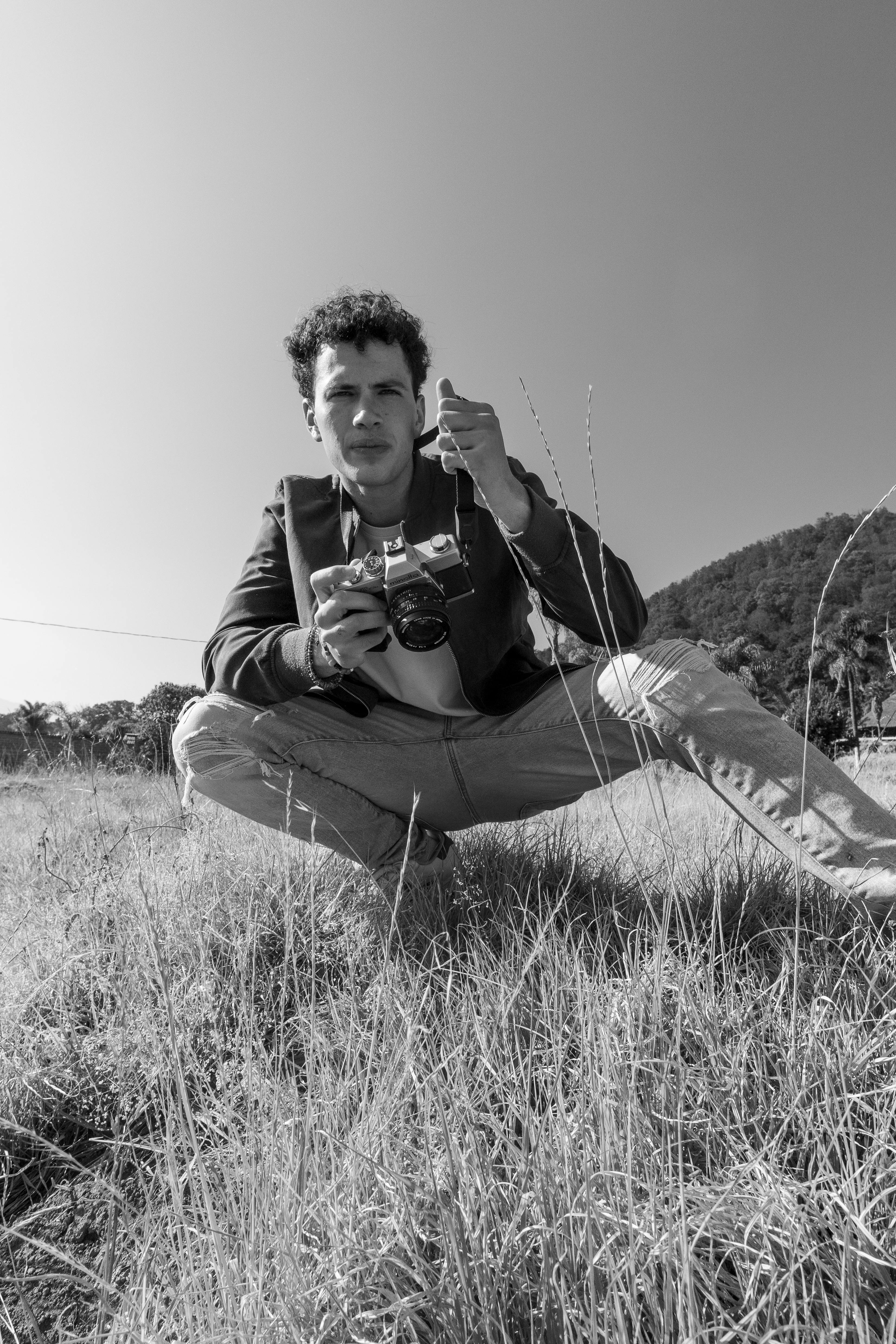Black and White Shot of a Photographer Crouching with a Camera in his ...