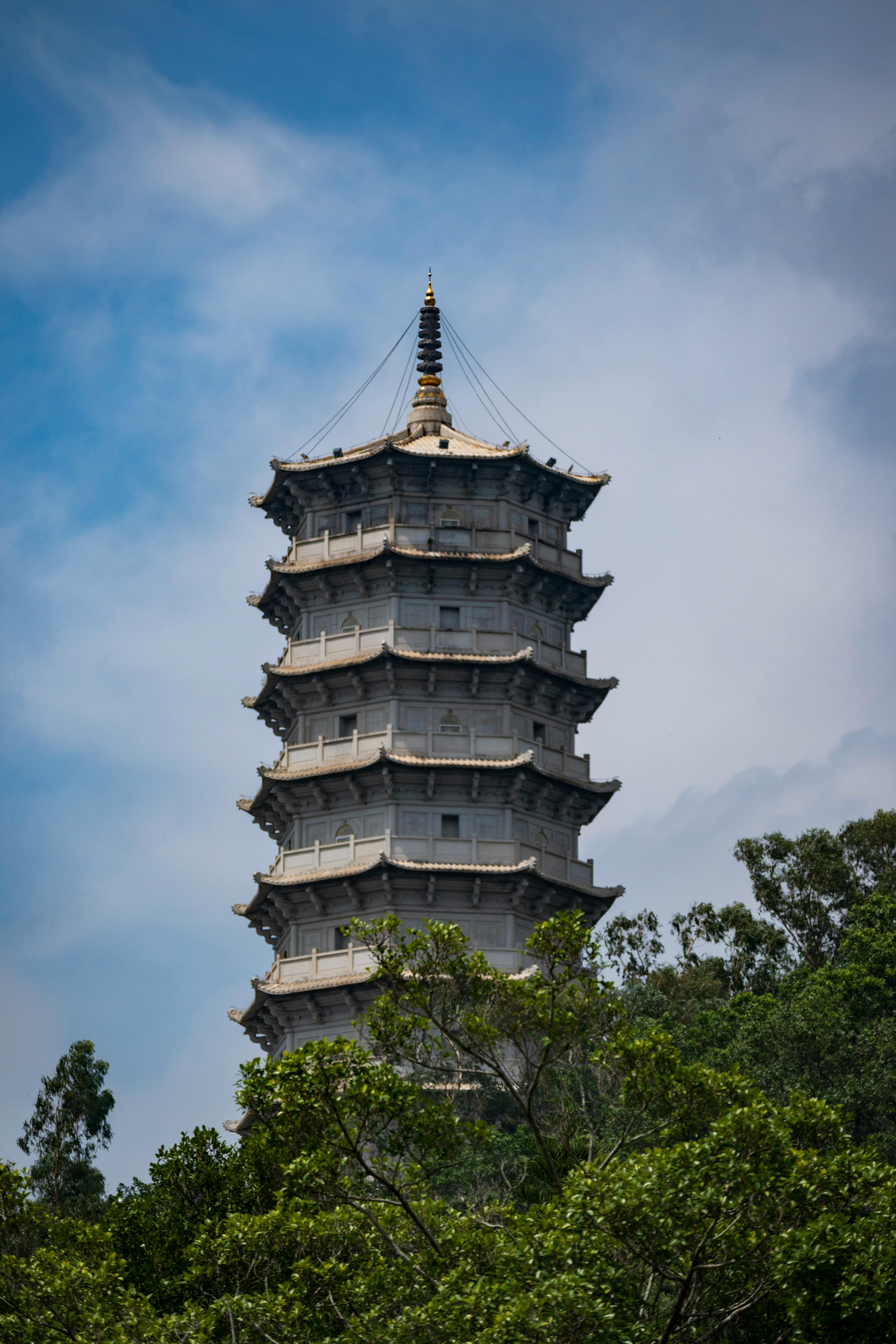 A tall pagoda tower is sitting on top of a hill · Free Stock Photo