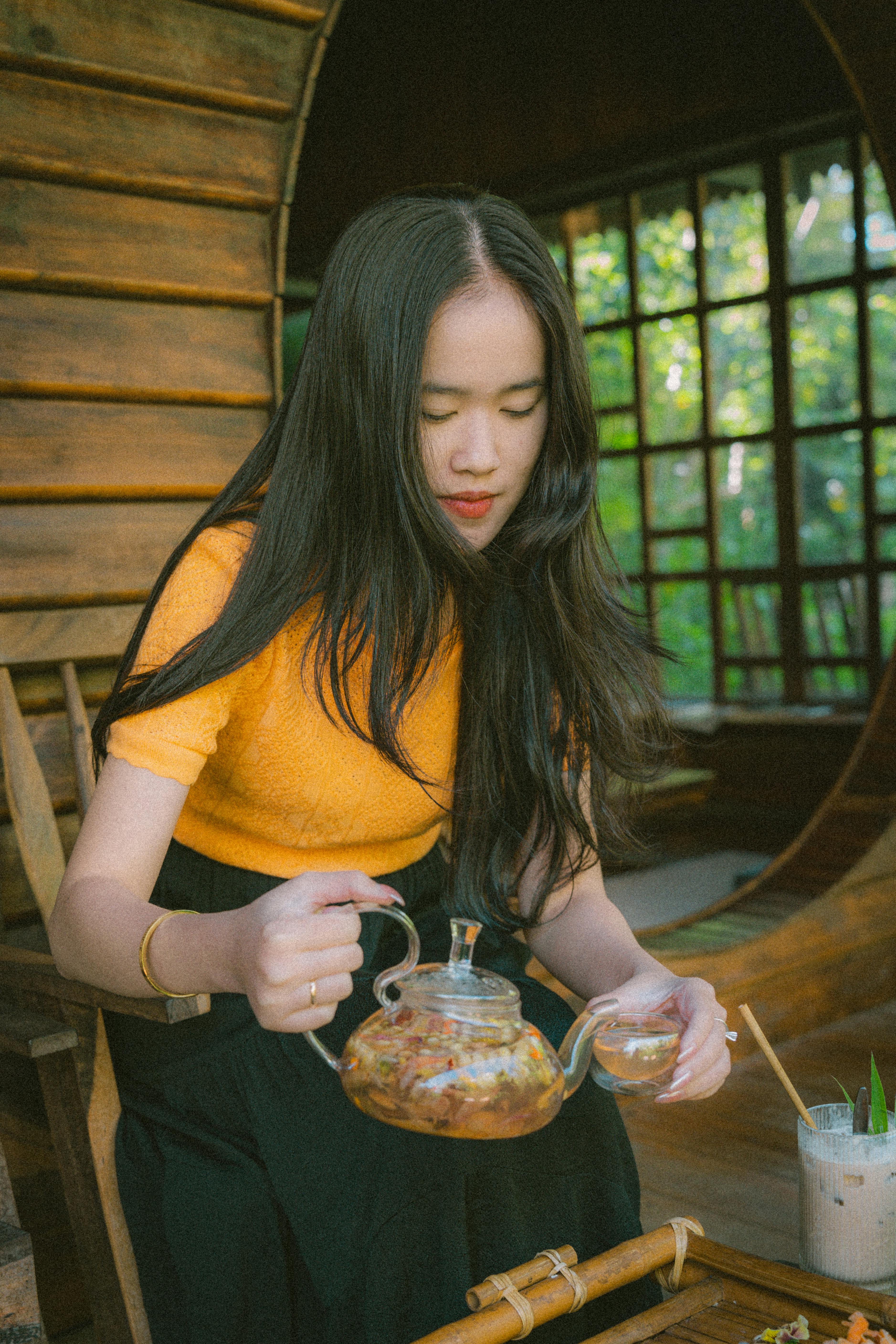 Woman Sitting and Pouring Tea · Free Stock Photo