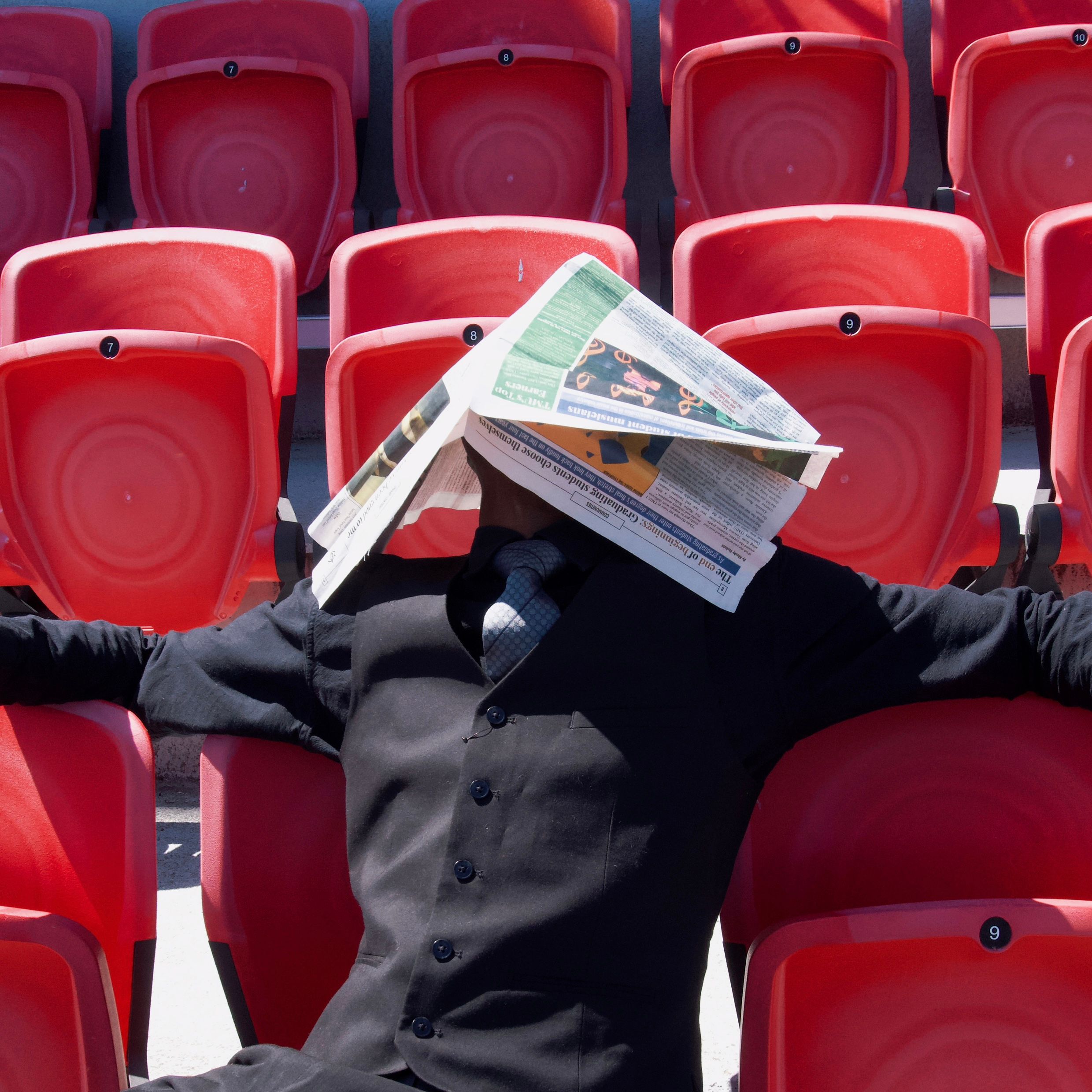 Model in Suit Posing with Newspaper on Head · Free Stock Photo