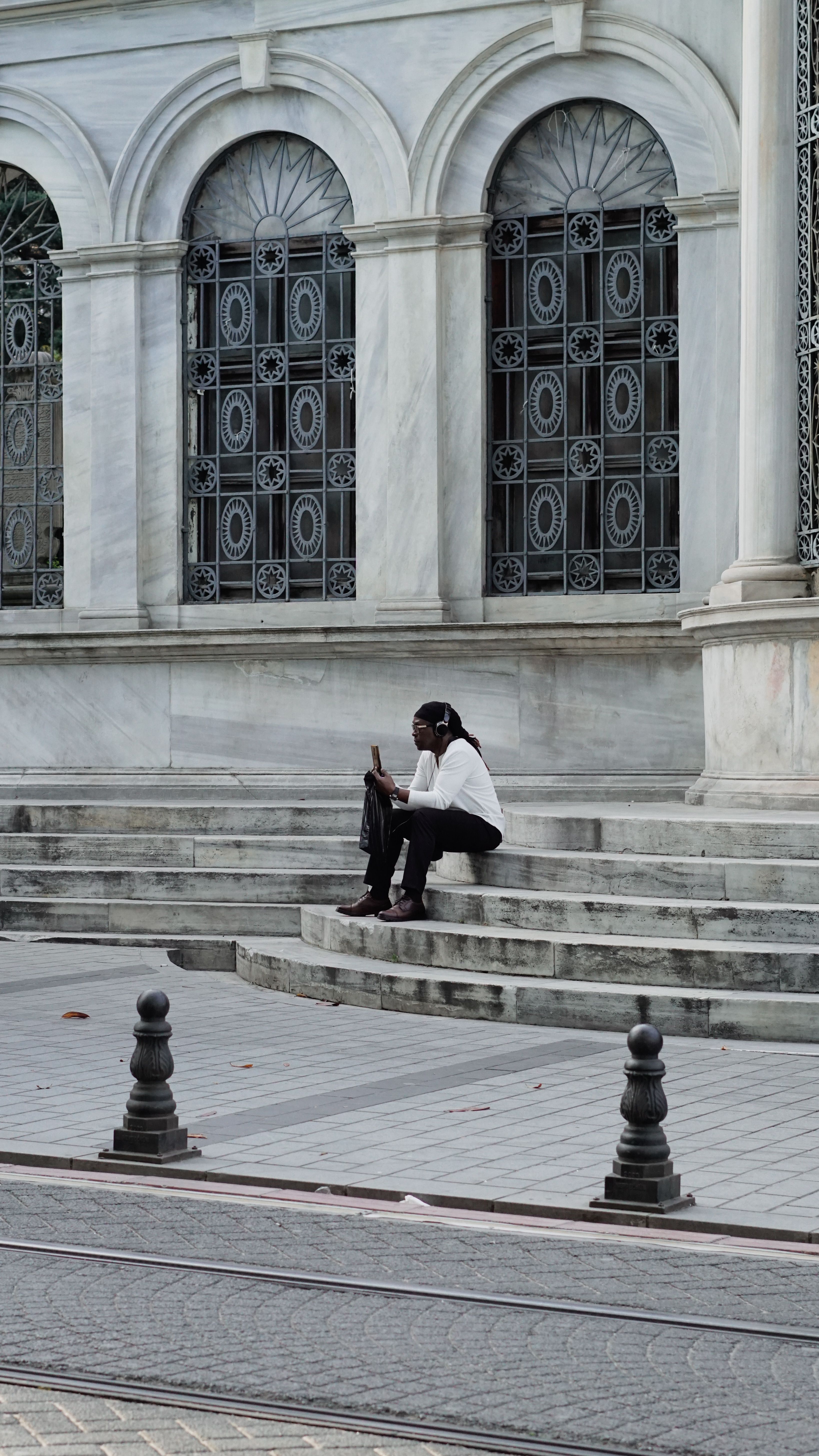 A man sitting on the steps of a building · Free Stock Photo