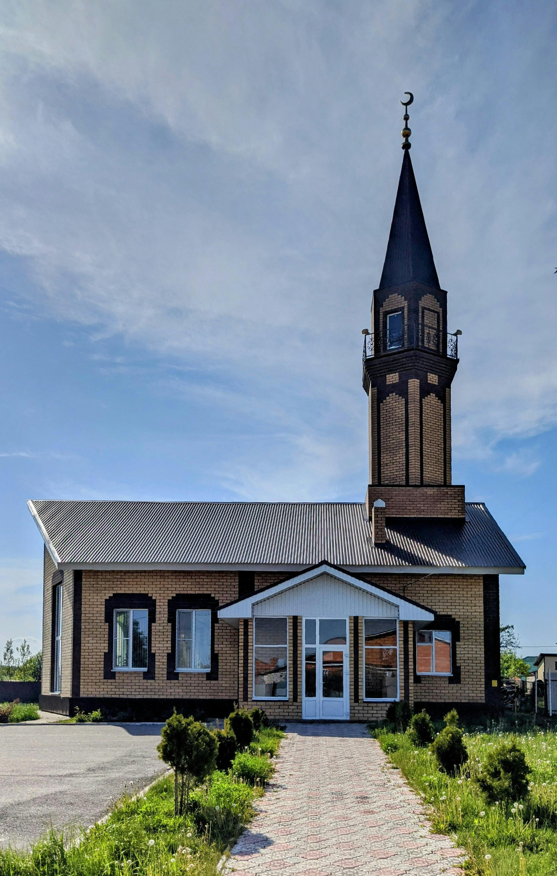 A church with a steeple and a brick building · Free Stock Photo