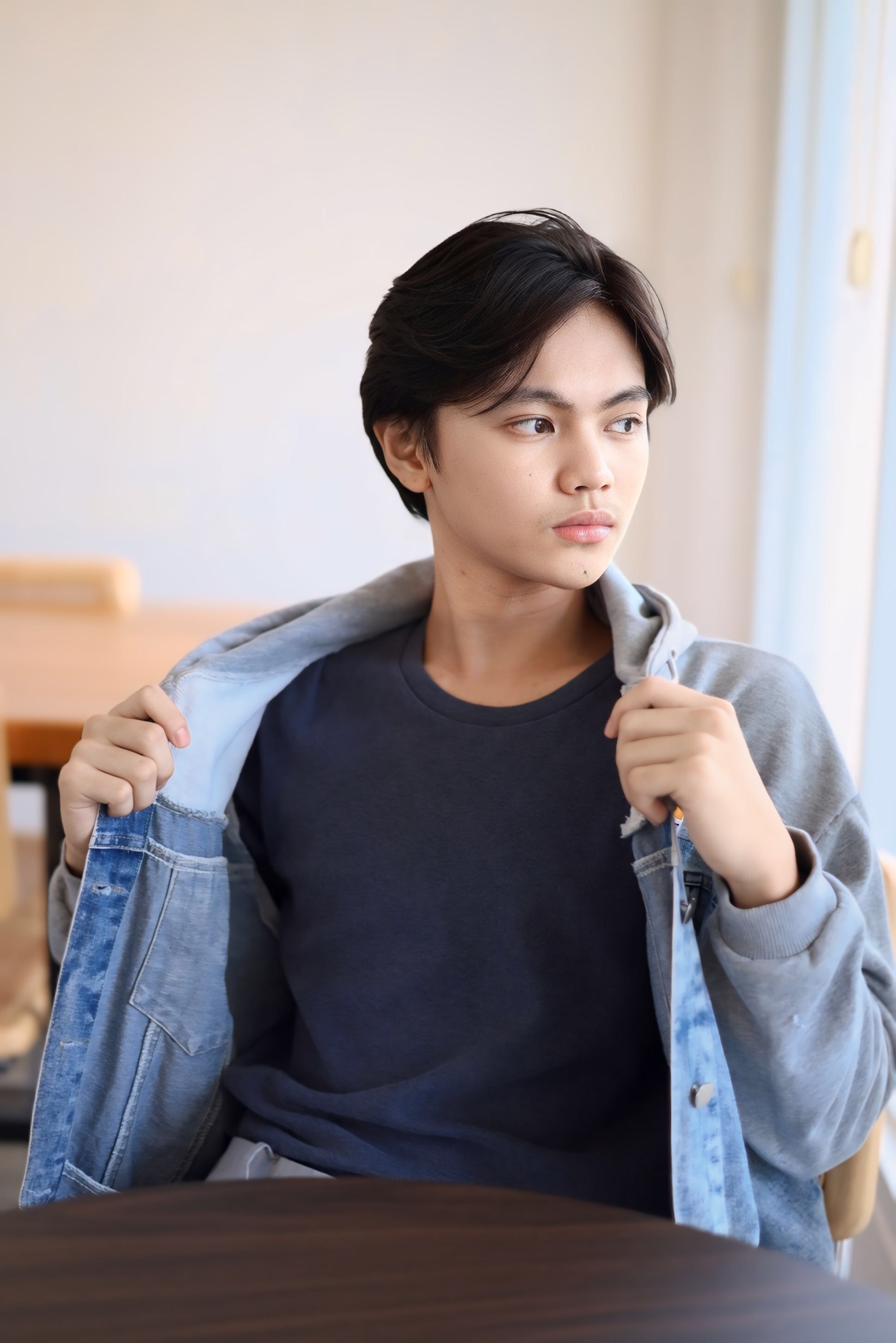 A Boy in a Denim Jacket Sitting at the Table · Free Stock Photo