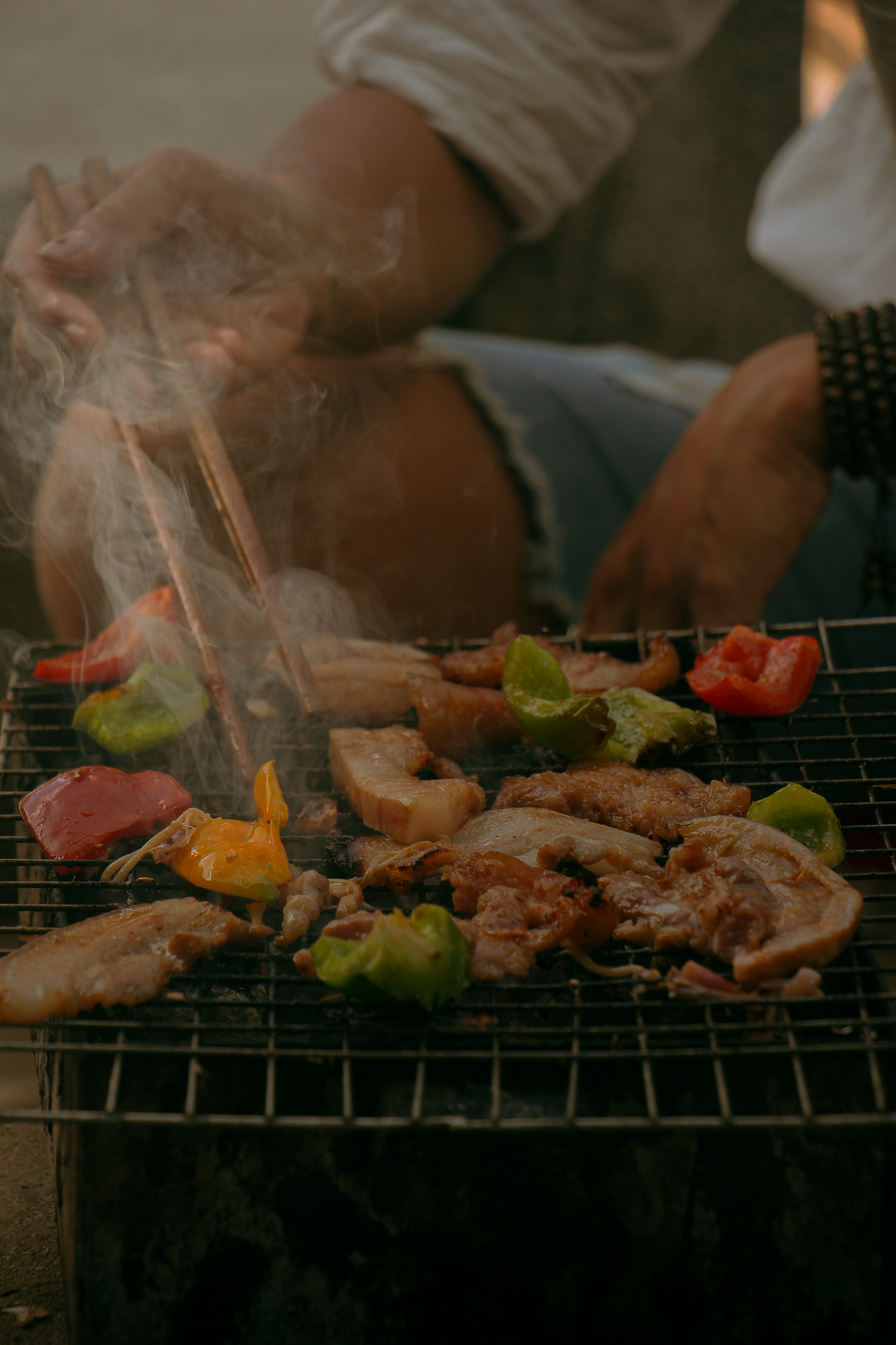 Man Sitting and Roasting Meat on Barbecue · Free Stock Photo