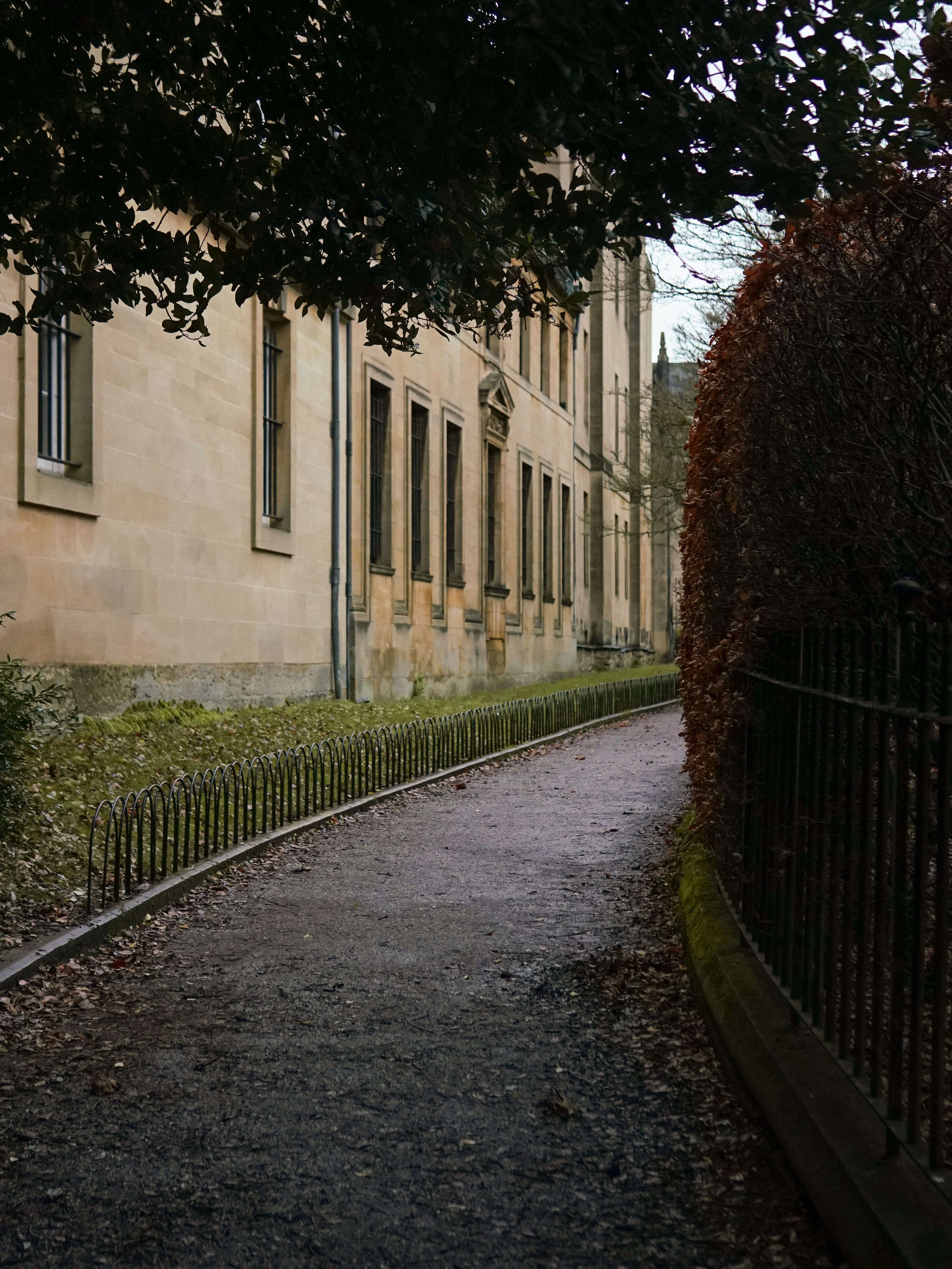 A path leading to a building with a fence · Free Stock Photo