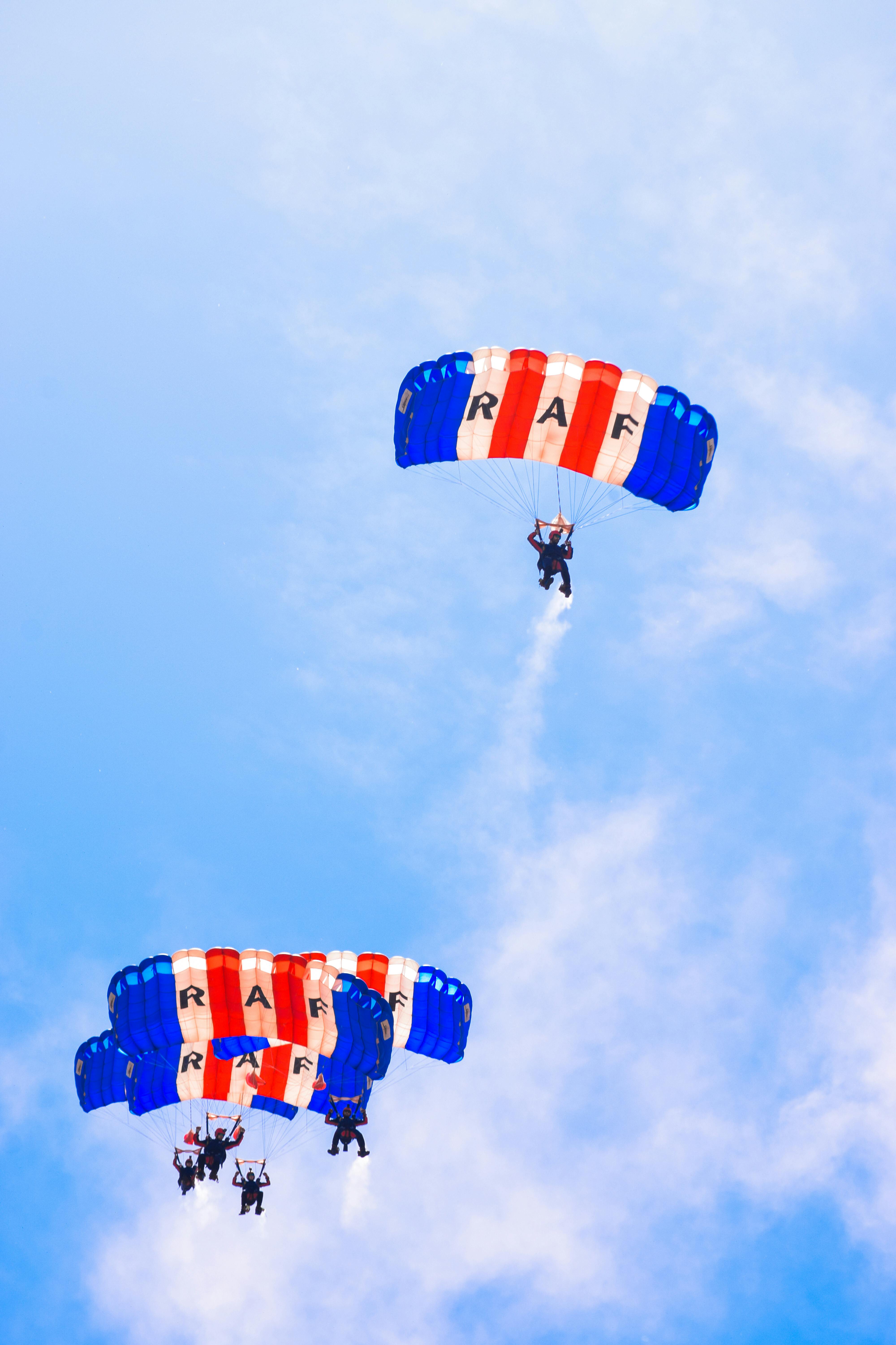 Low Angle Shot of People Falling with Parachutes · Free Stock Photo