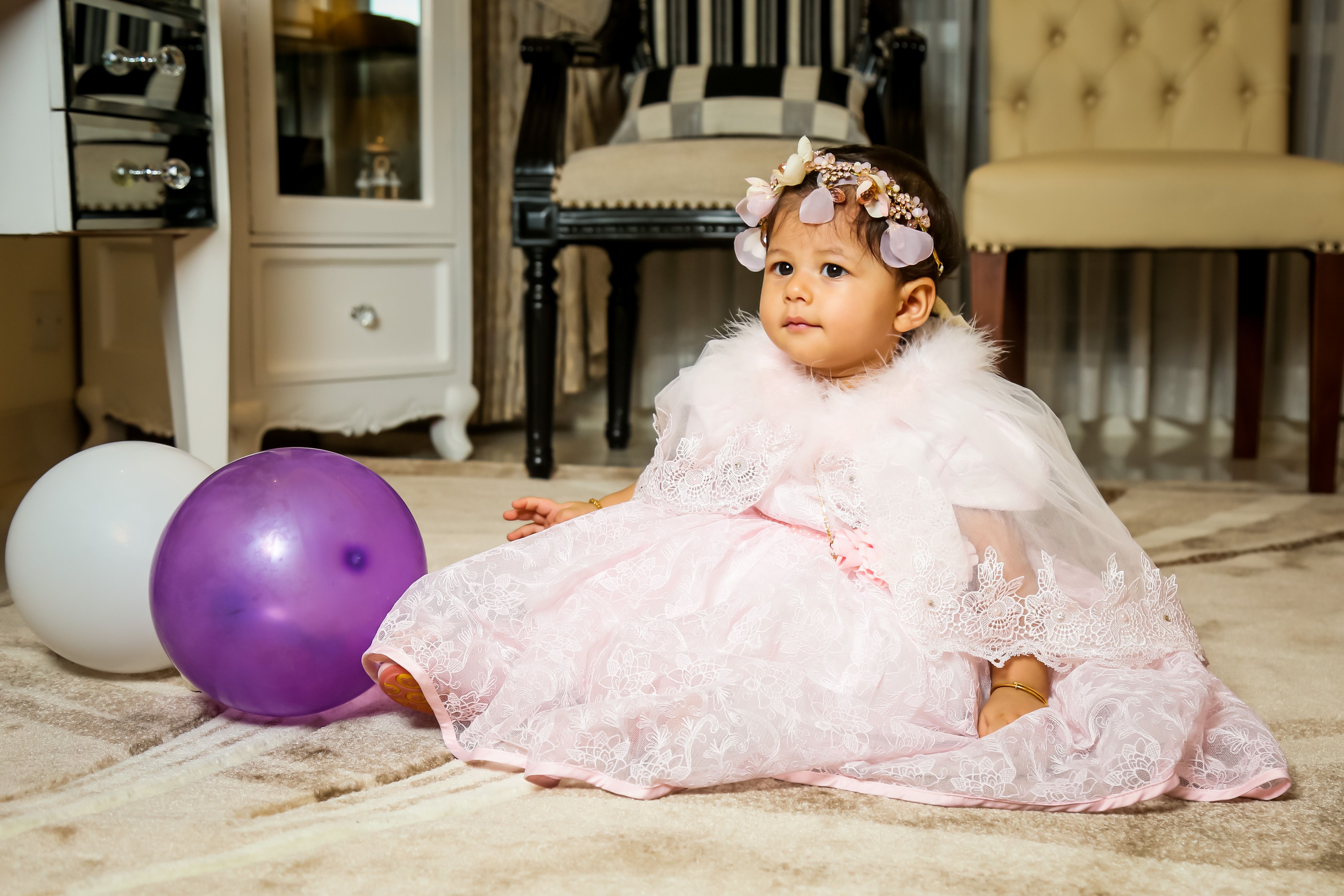 Cute Baby Girl Wearing a Pink Dress Sitting on the Floor · Free Stock Photo