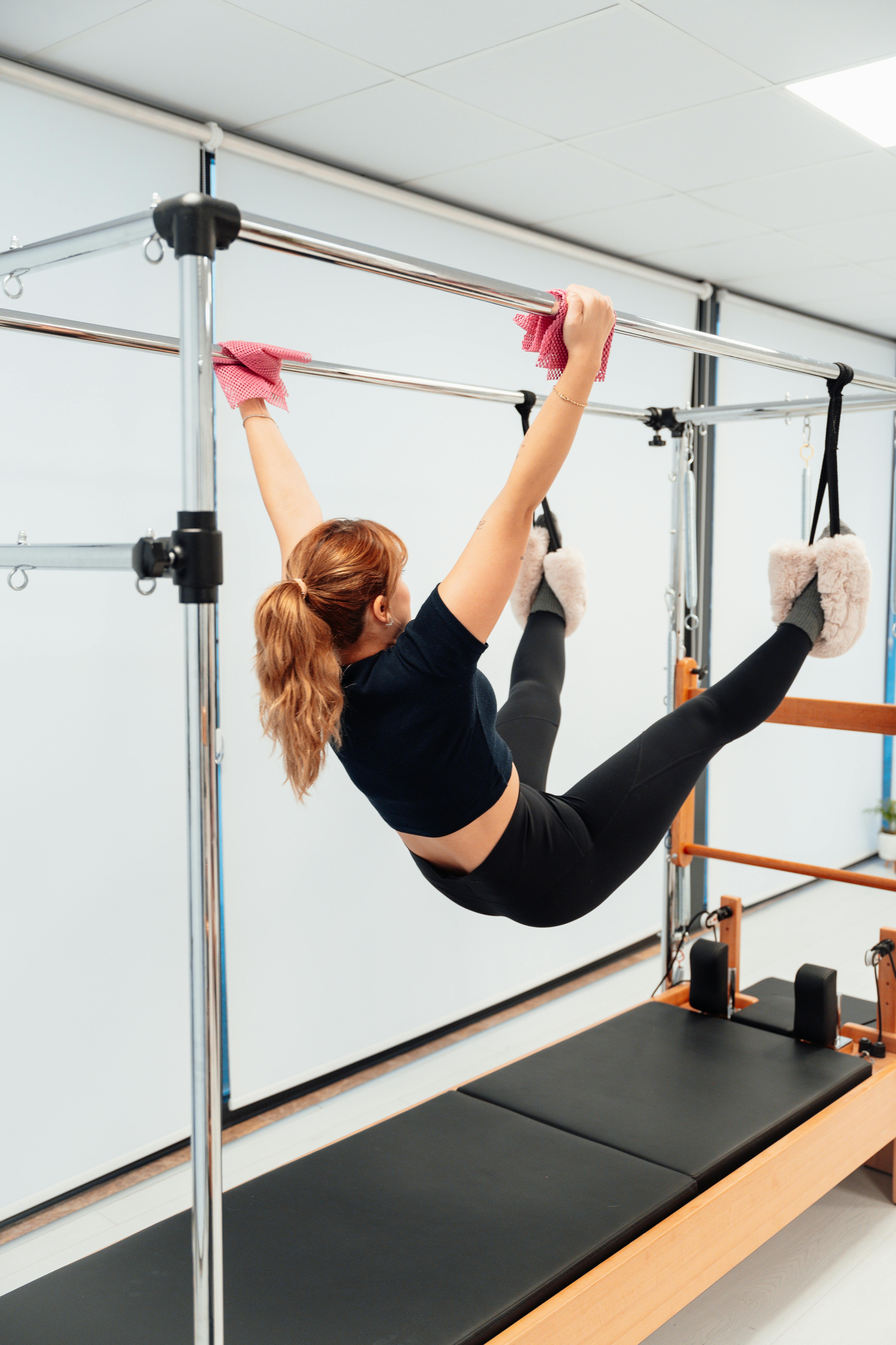Woman Hanging on a Pilates Cadillac Machine · Free Stock Photo