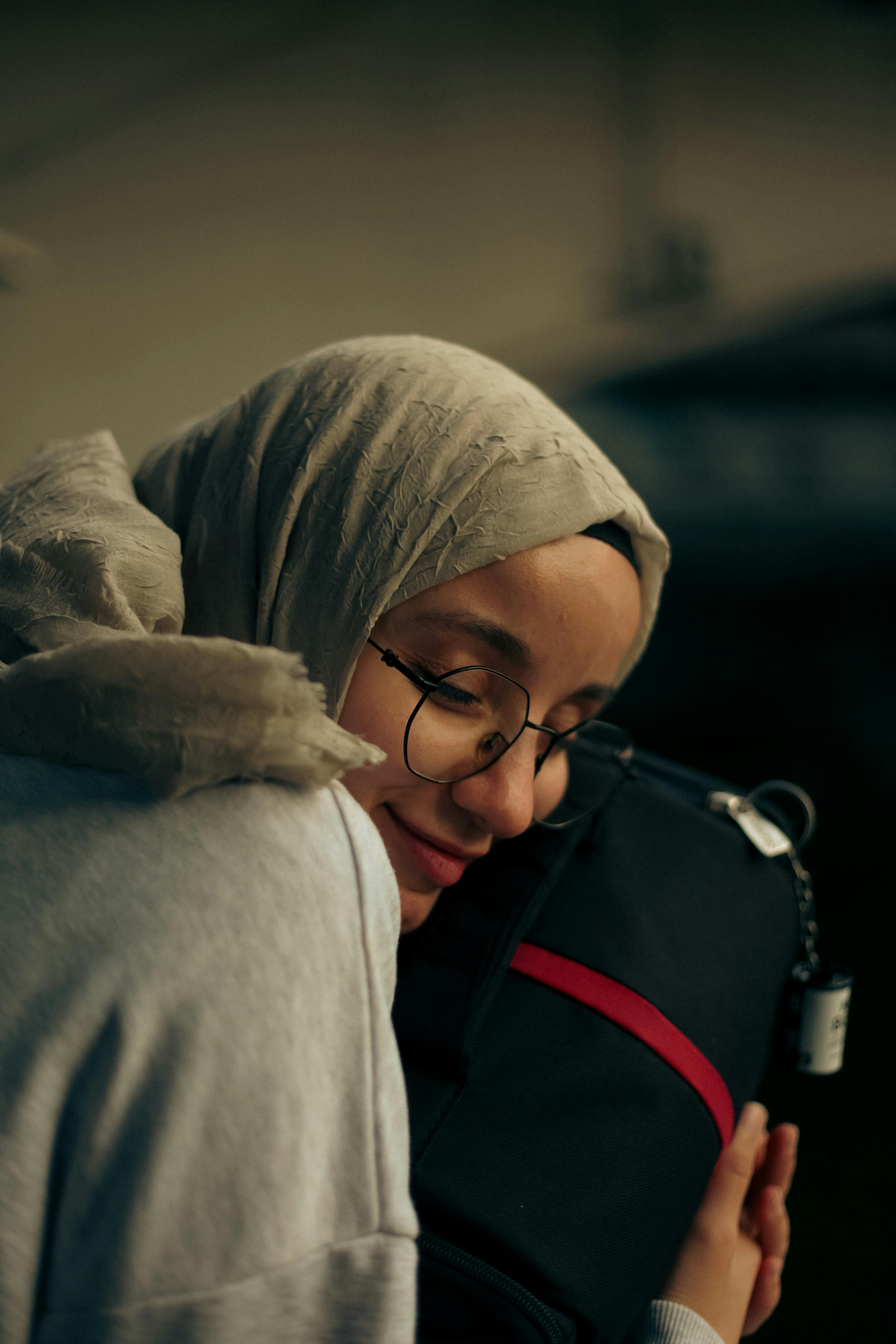 Portrait of a Woman in Hijab Hugging a Backpack · Free Stock Photo