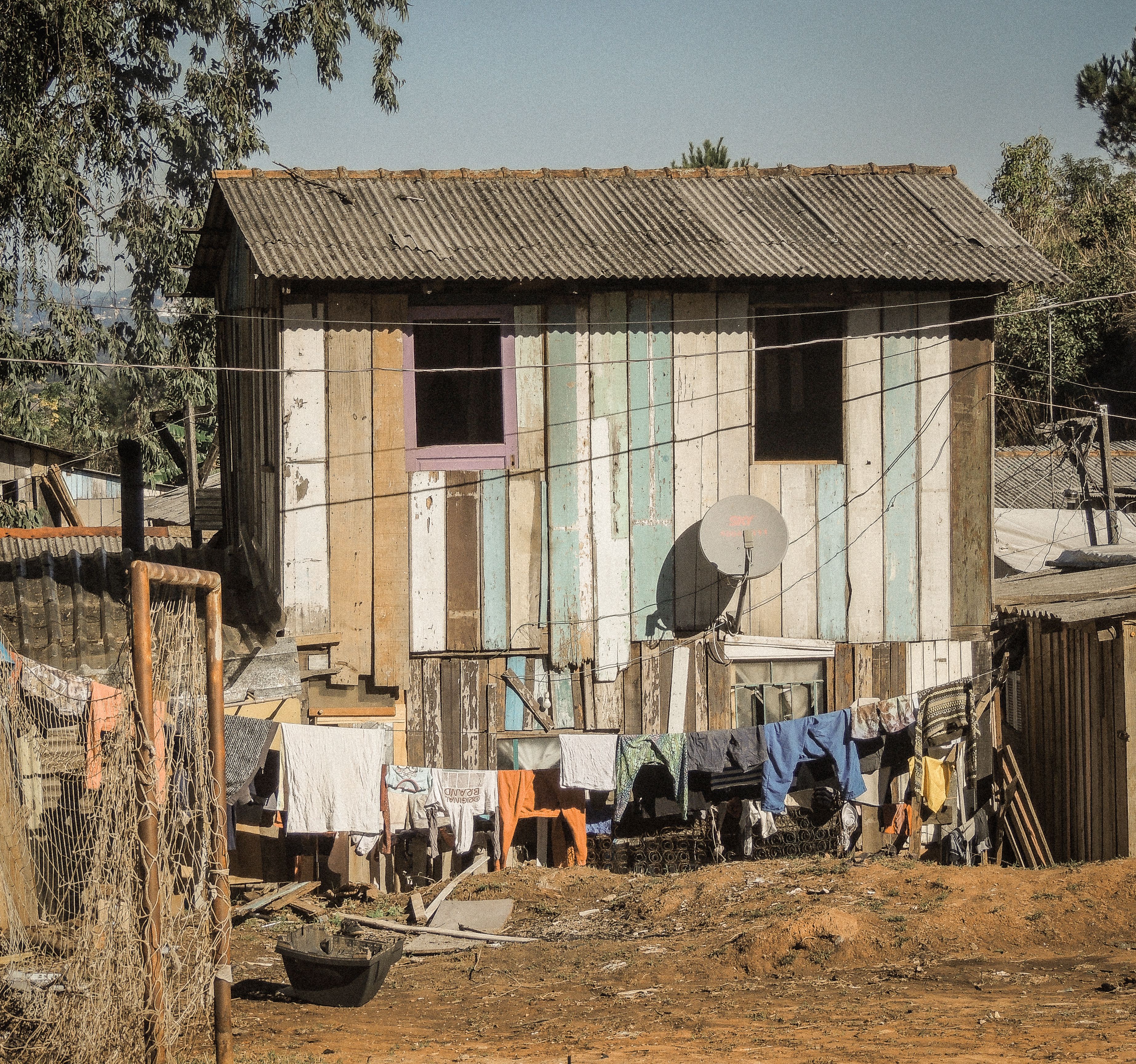 Laundry Drying in Front of a House Made of Random Boards · Free Stock Photo