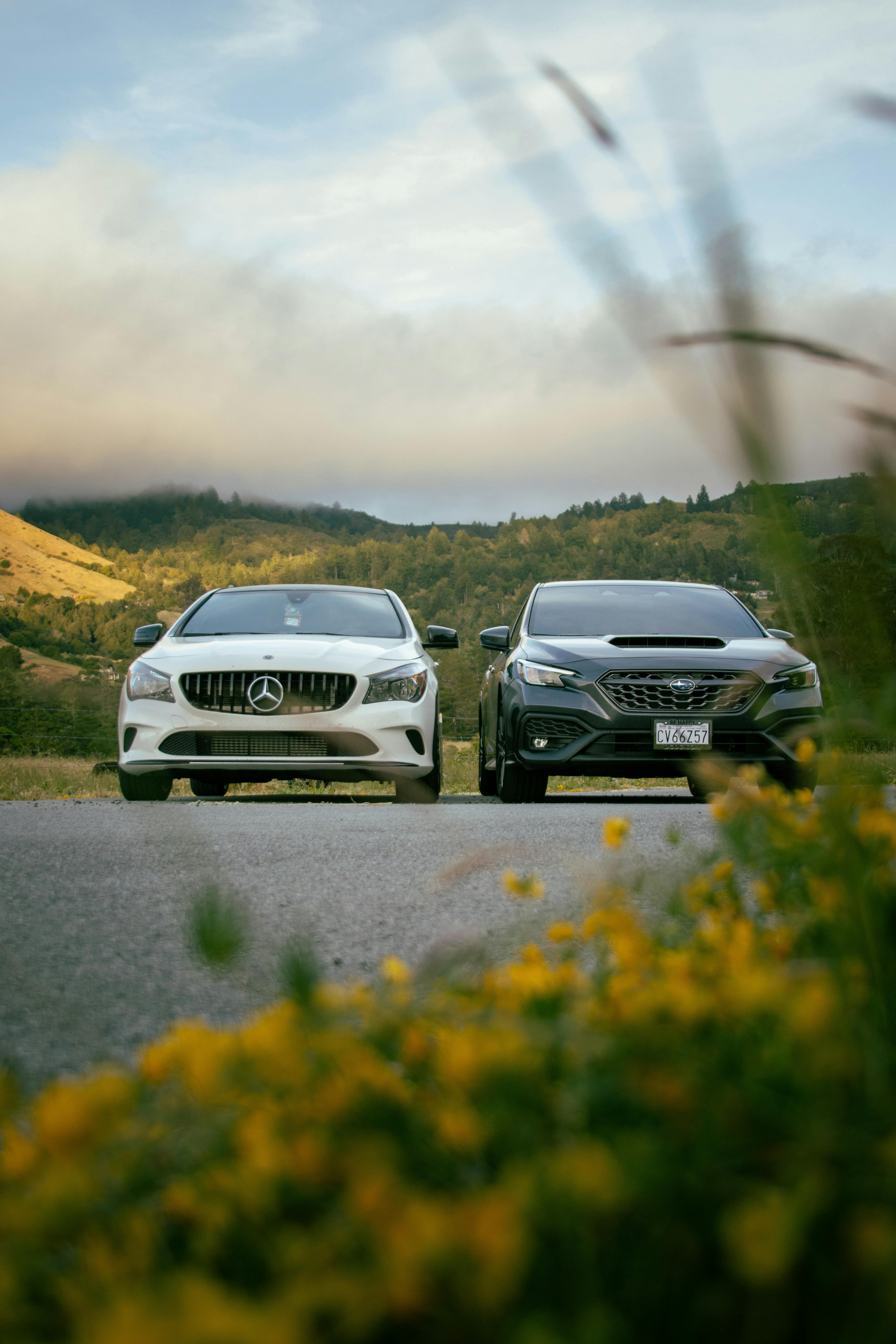 Two cars parked side by side on a road · Free Stock Photo