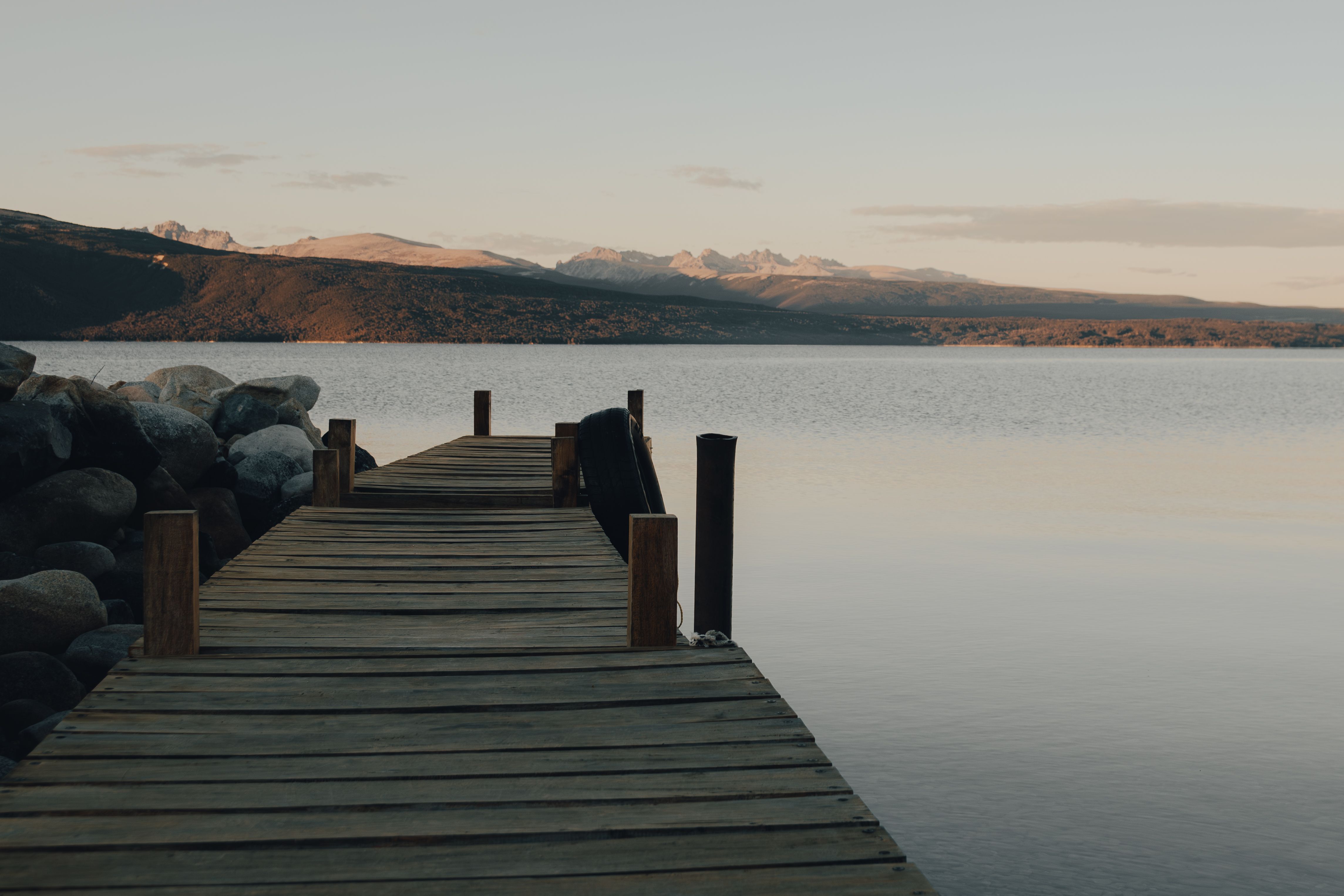 Empty Jetty at Dusk with Hills and Mountains in the Background · Free ...