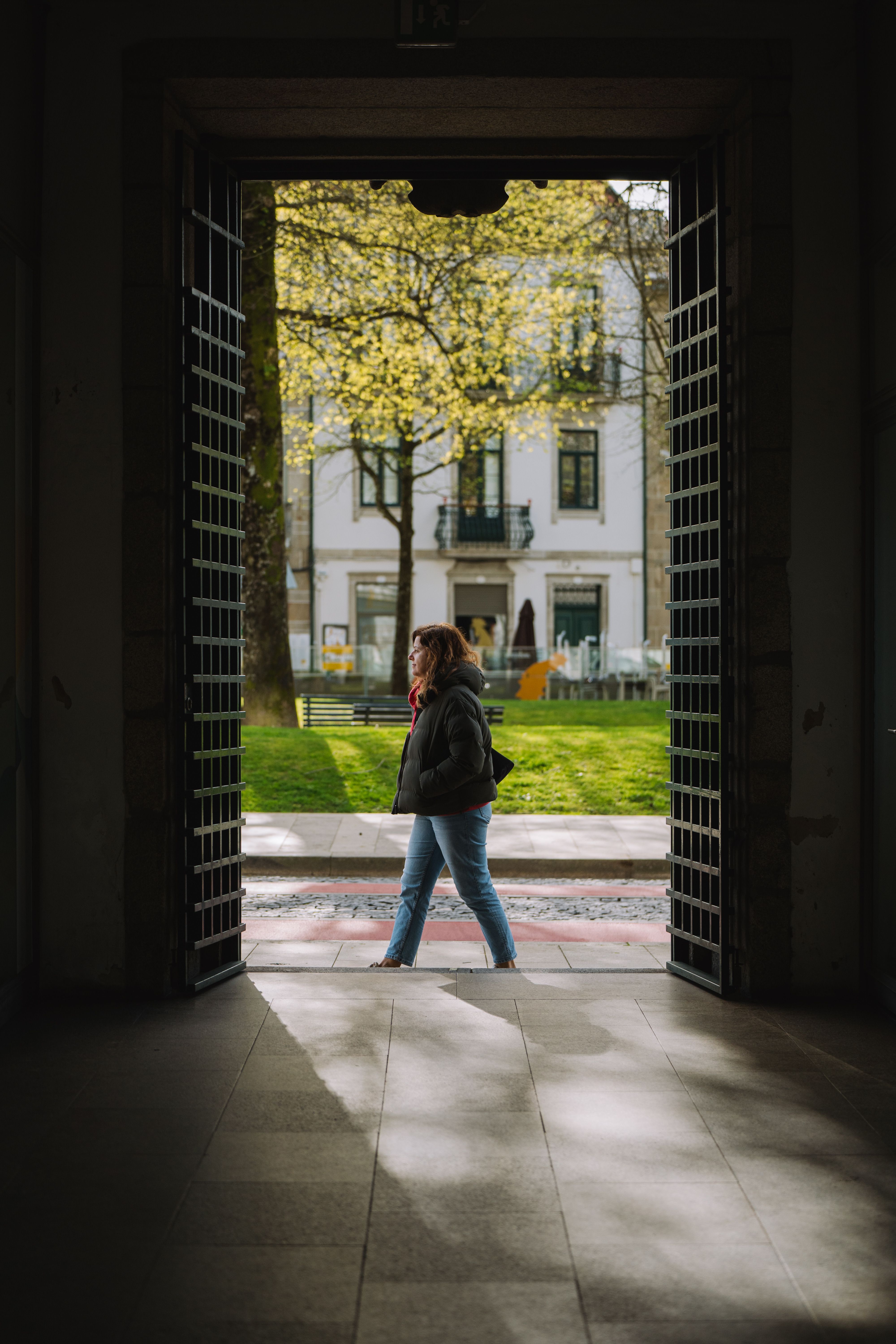 Female Pedestrian Walking past an Open Gate · Free Stock Photo