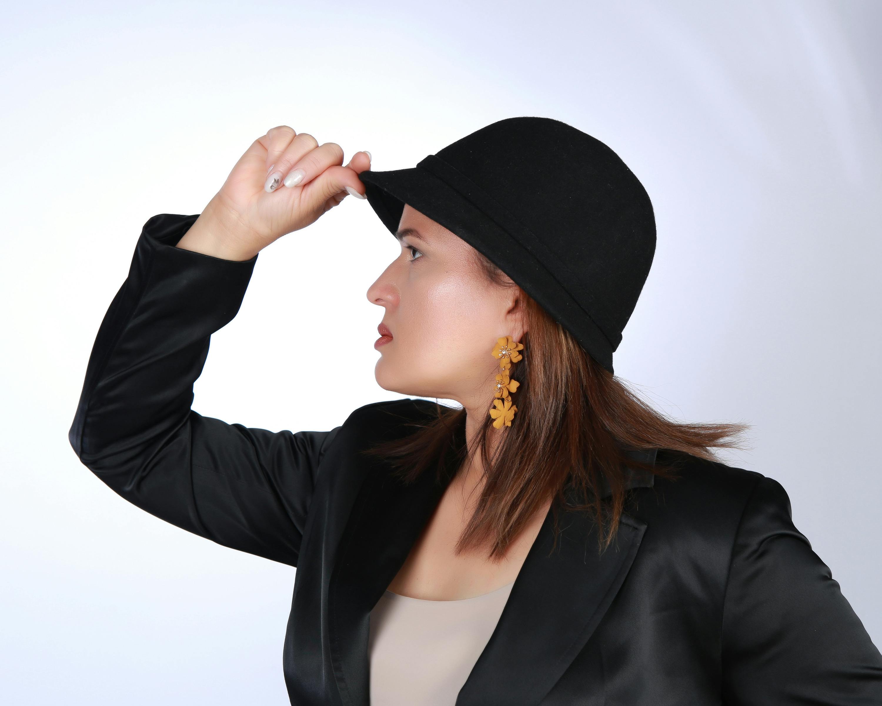 Woman Fixing Hat on her Head · Free Stock Photo