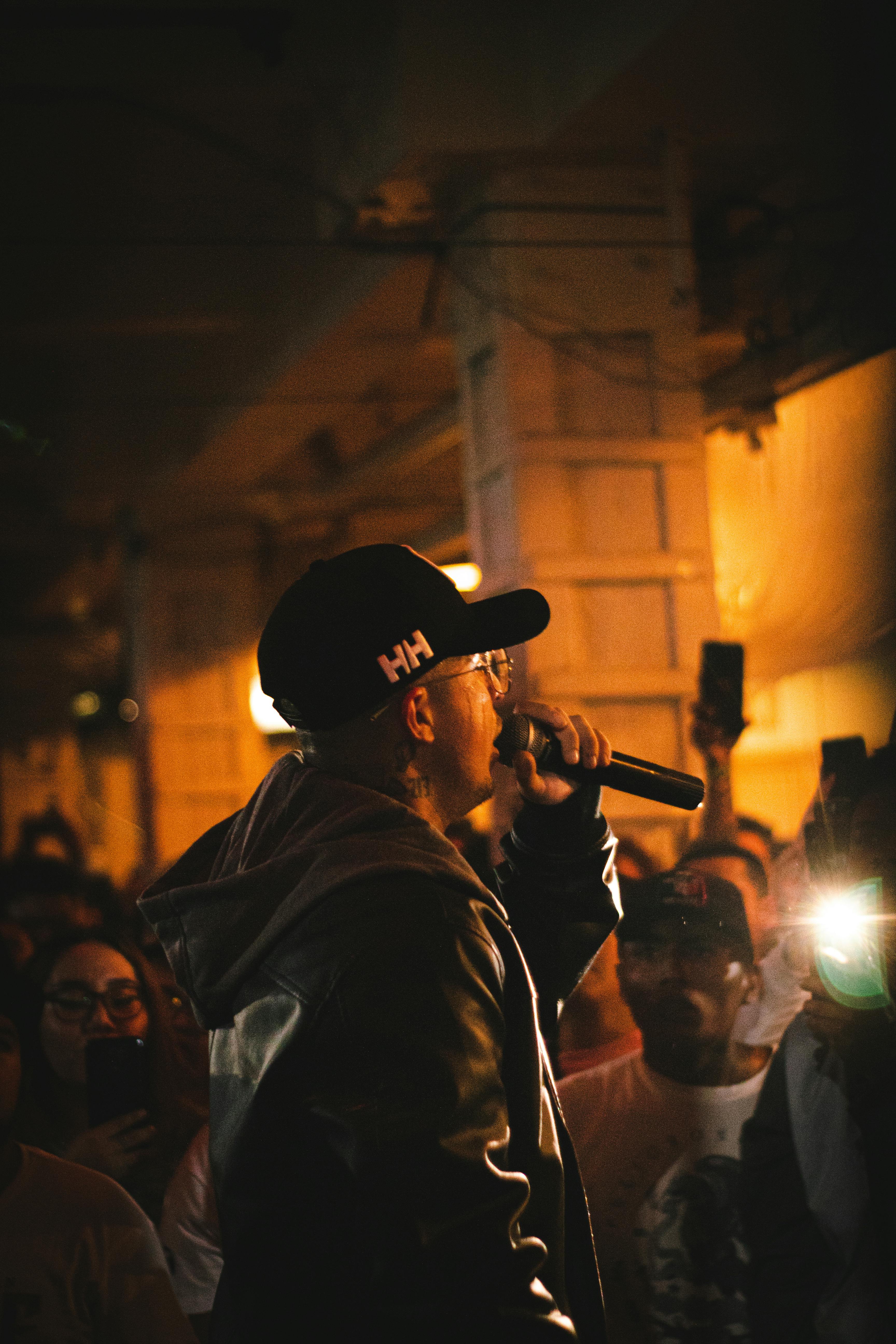 Singer Performing on Dark Stage · Free Stock Photo