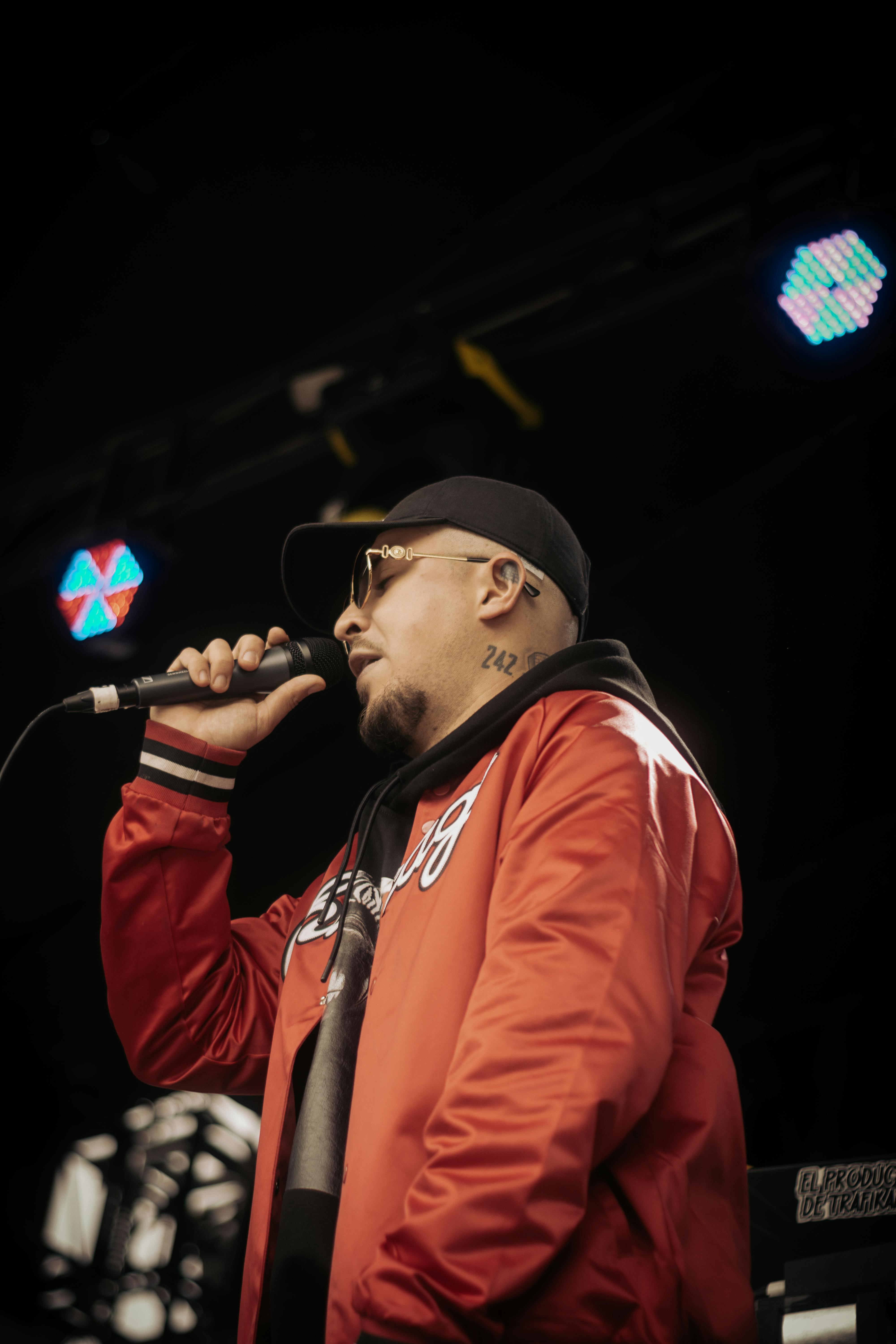 Man With Dreadlocks and Sunglasses Poses Near Tupac Shakur Portrait ...