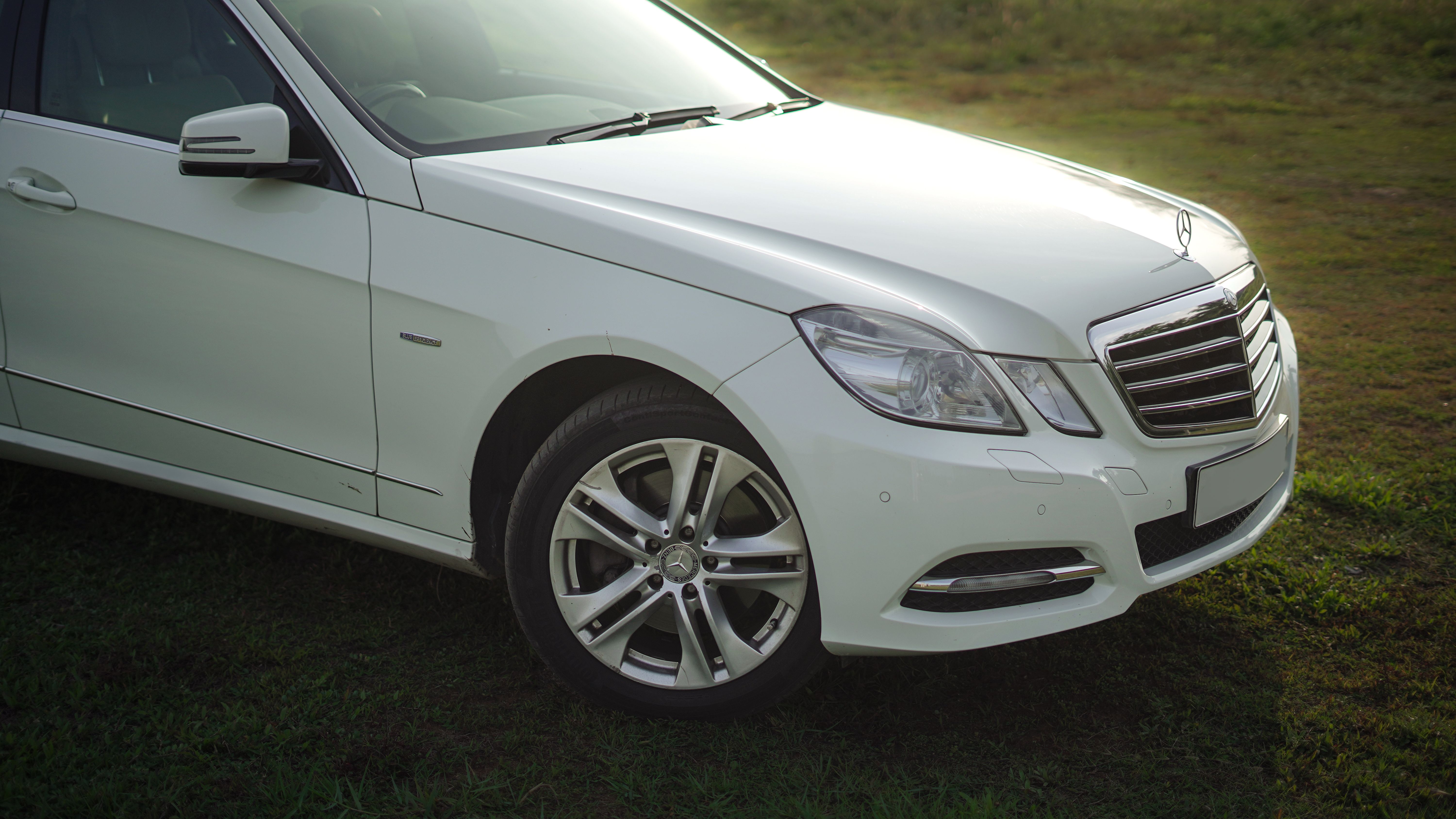 A white mercedes benz car parked in a field · Free Stock Photo