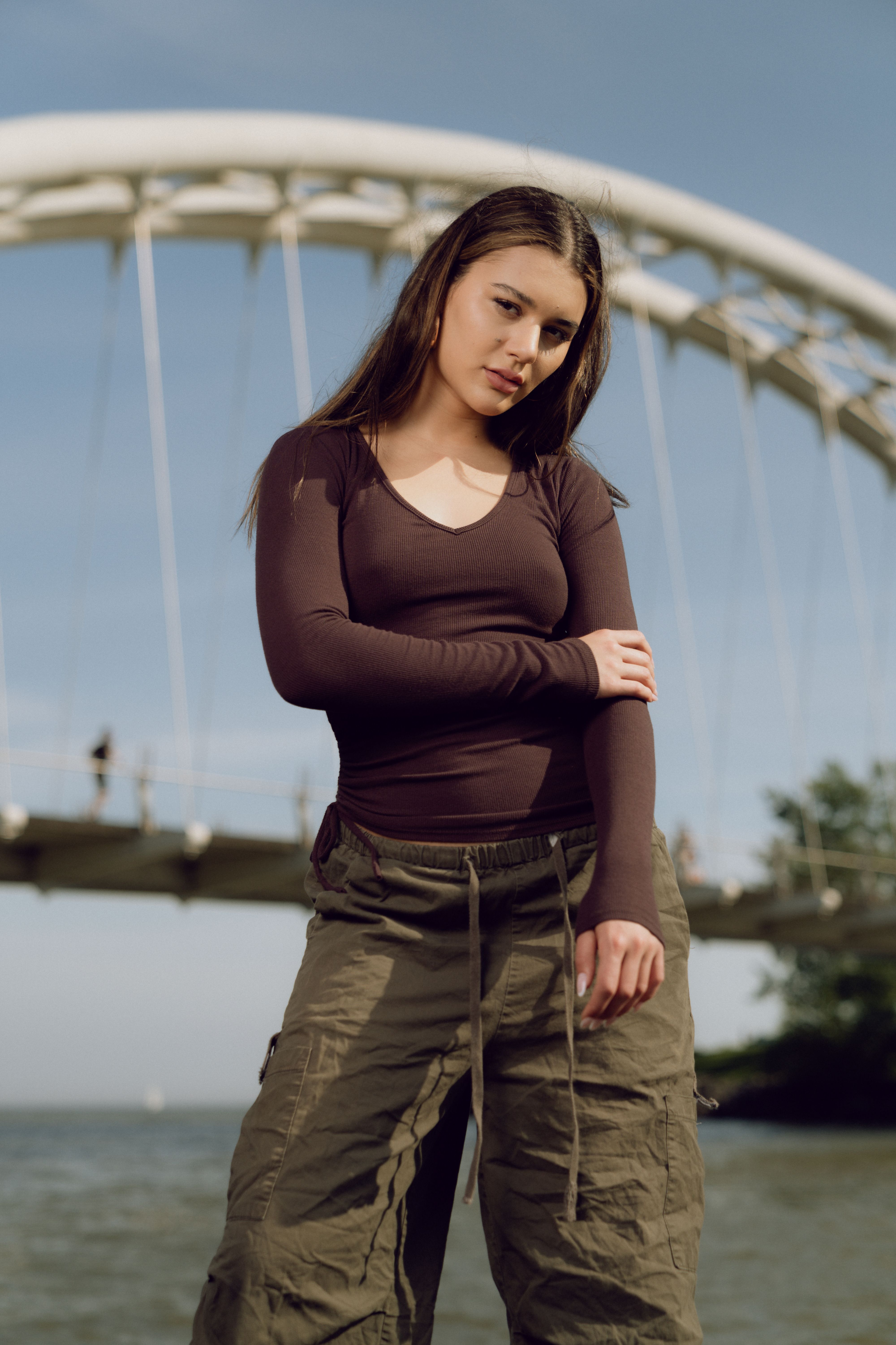 Standing against Bridge Woman in Blouse and Cargo Pants · Free Stock Photo