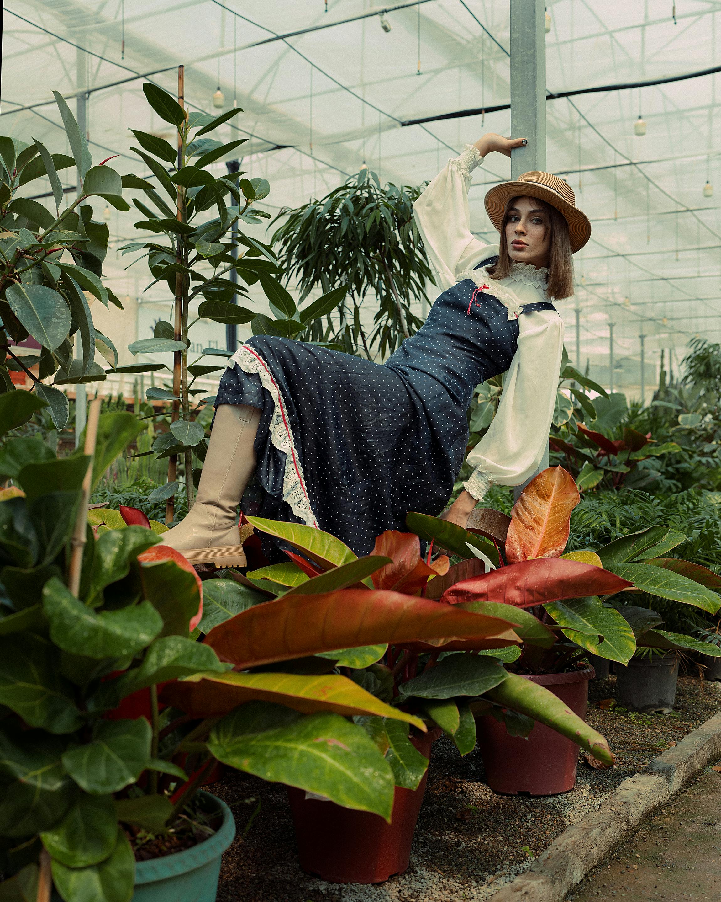Woman in a Dress Posing in a Tropical Plant Nursery · Free Stock Photo